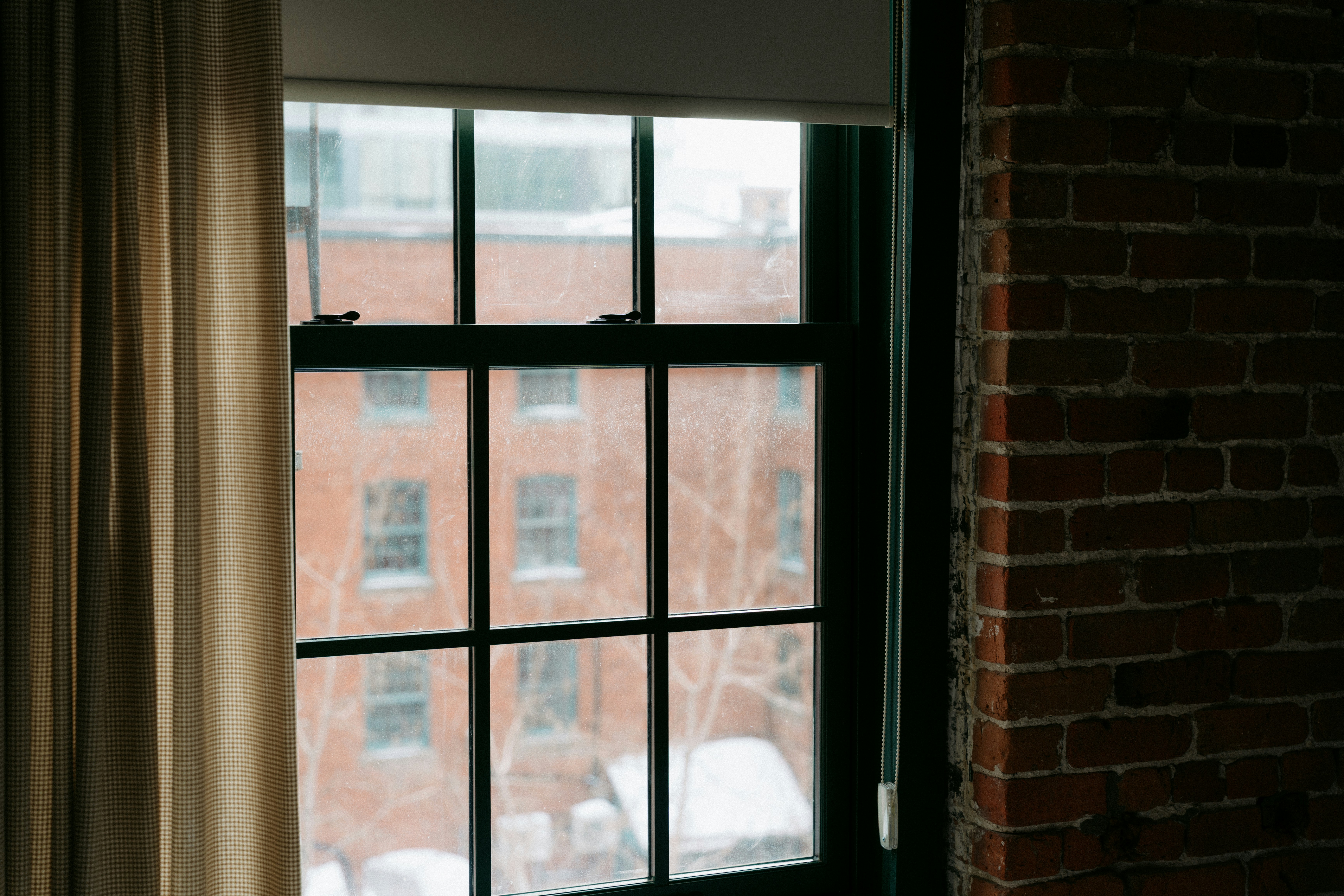 Brick Wall, Window Grid, and Soft Curtain—A Quiet Urban Light Study
