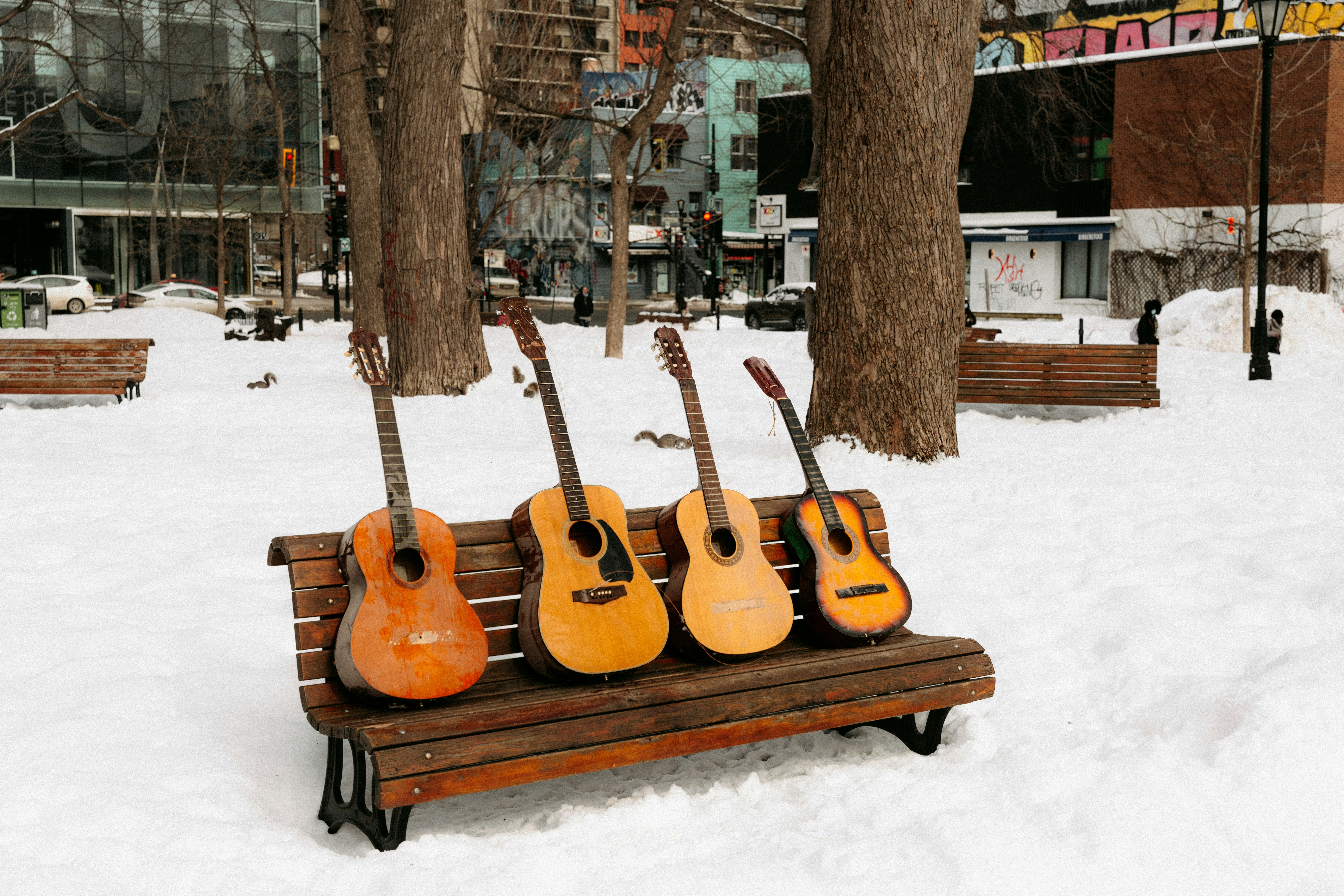 Guitars in Winter Silence: A Row of Old Melodies on a Snowy Park Bench