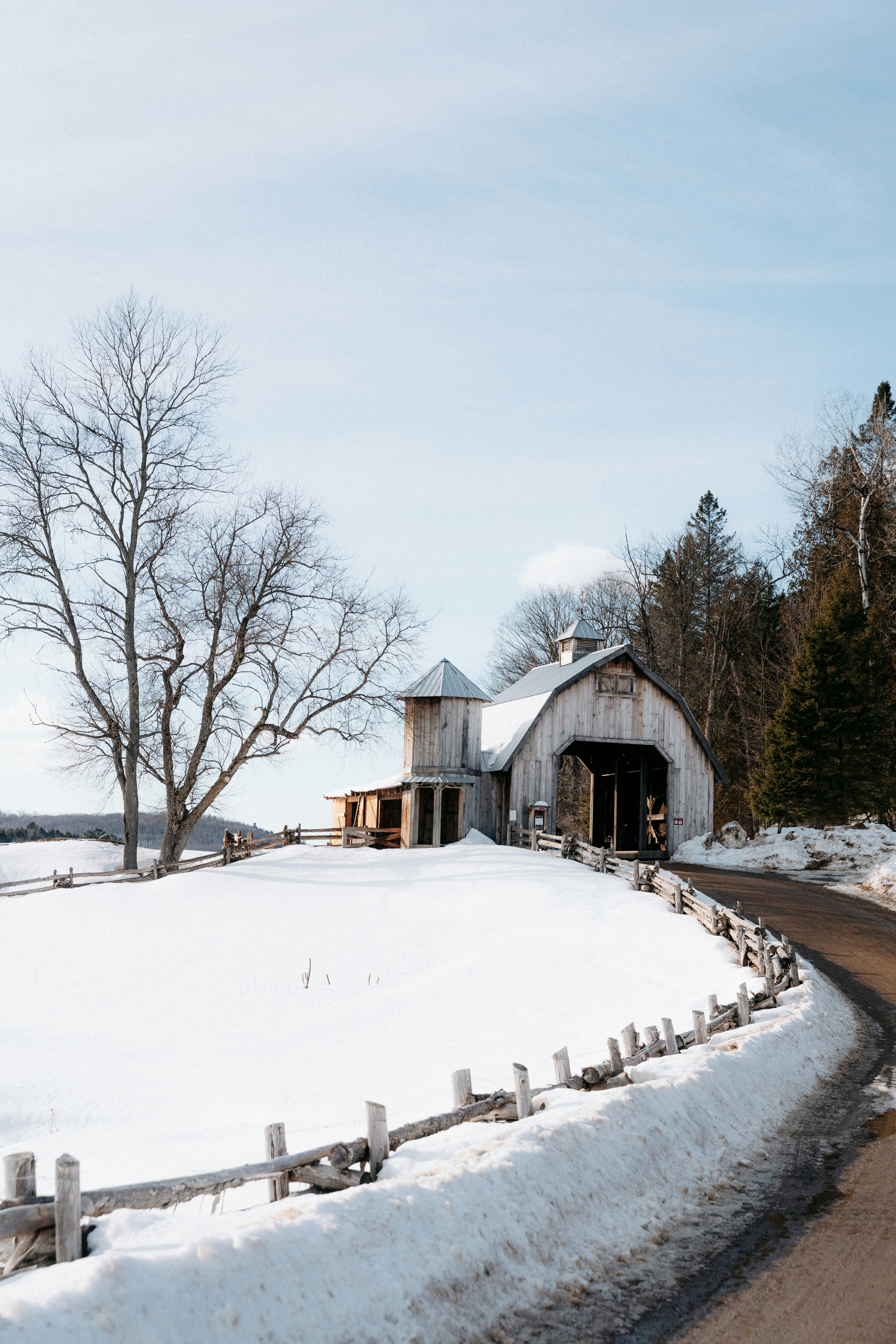 Snowbound Valley and Weathered Barn Along the Winding Road