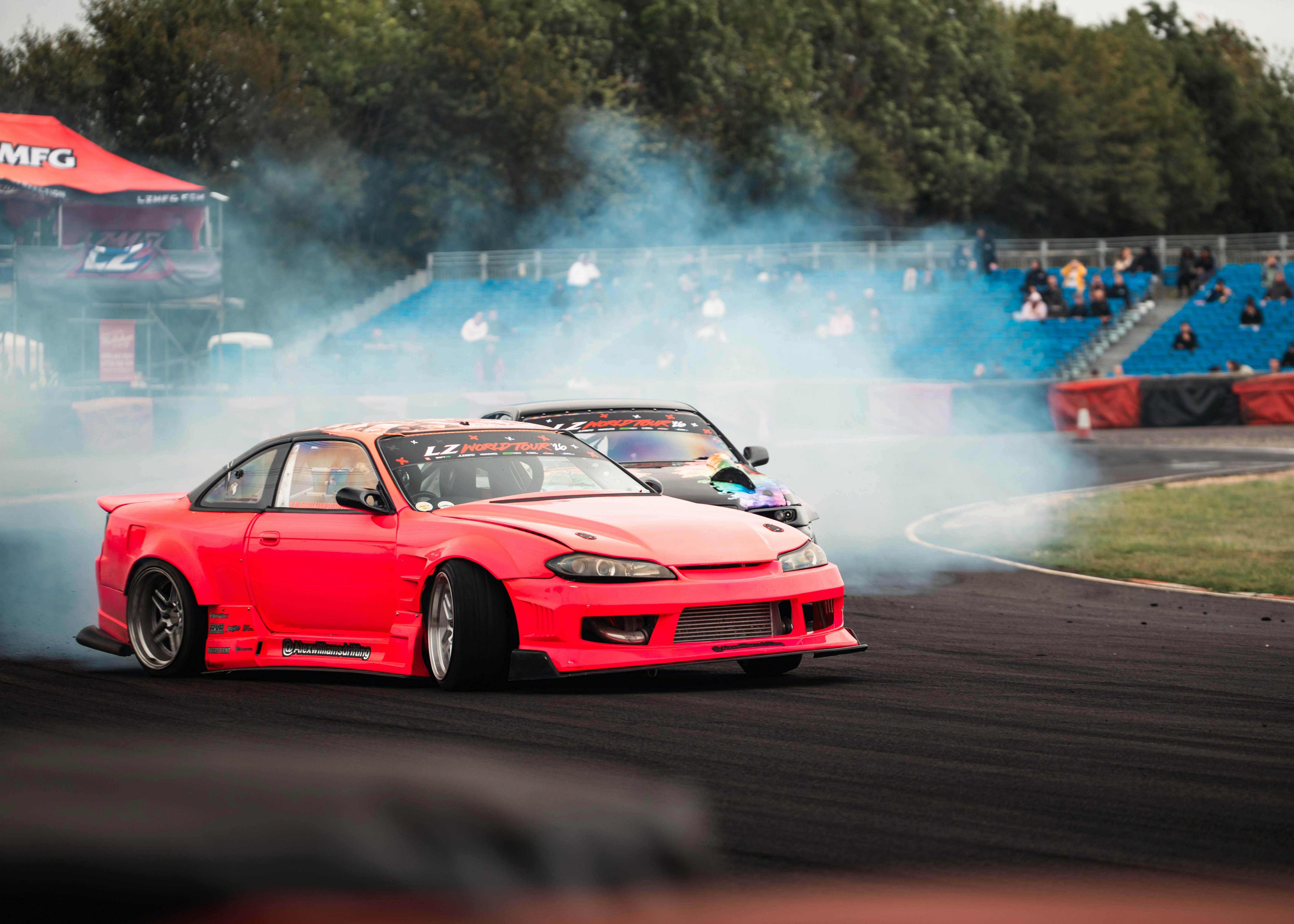 Red Blur of a Drift: A Neon-Covered Duo Races Past Smoke