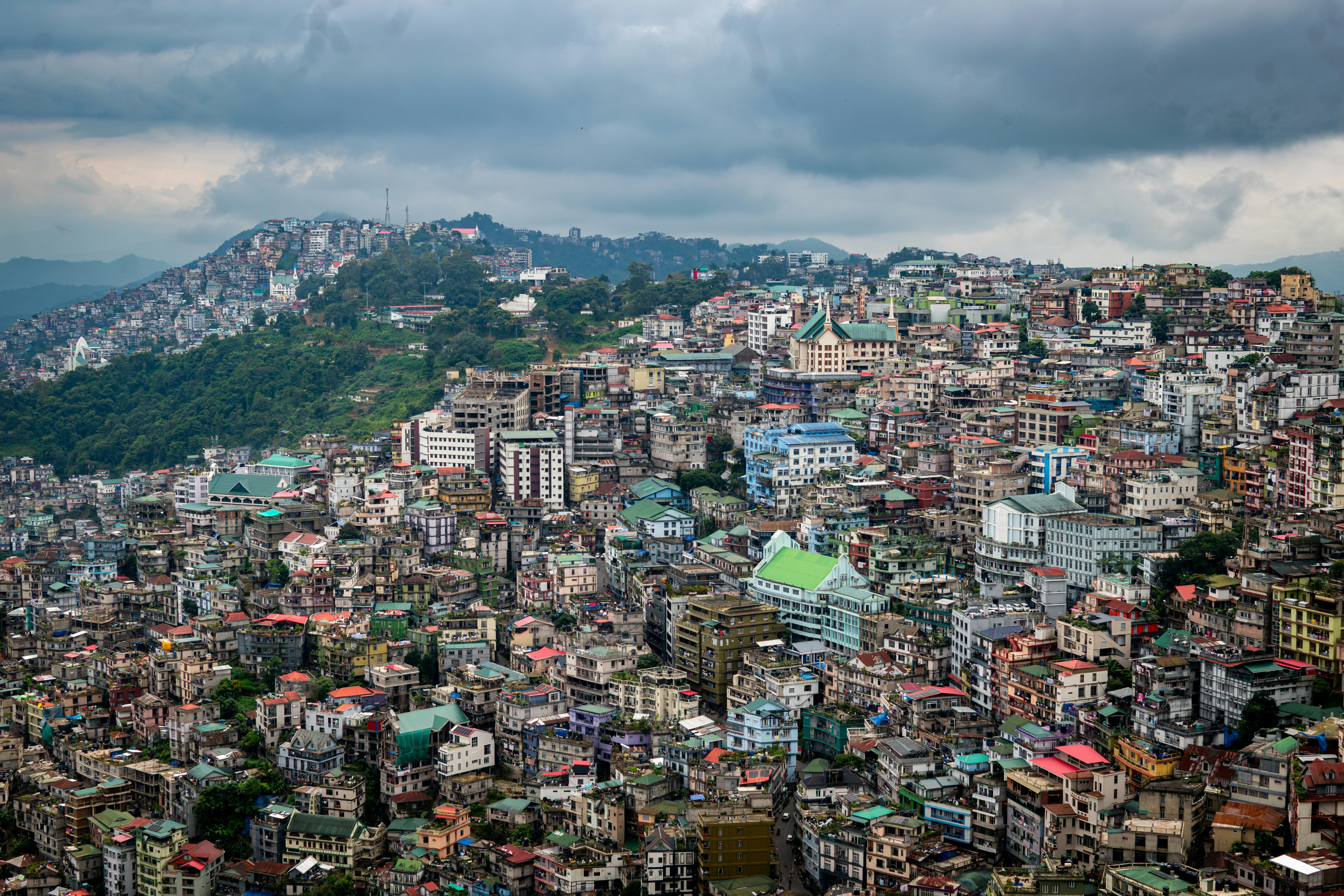 Urban Quilt: A Densely Packed Hill City Under Stormy Skies