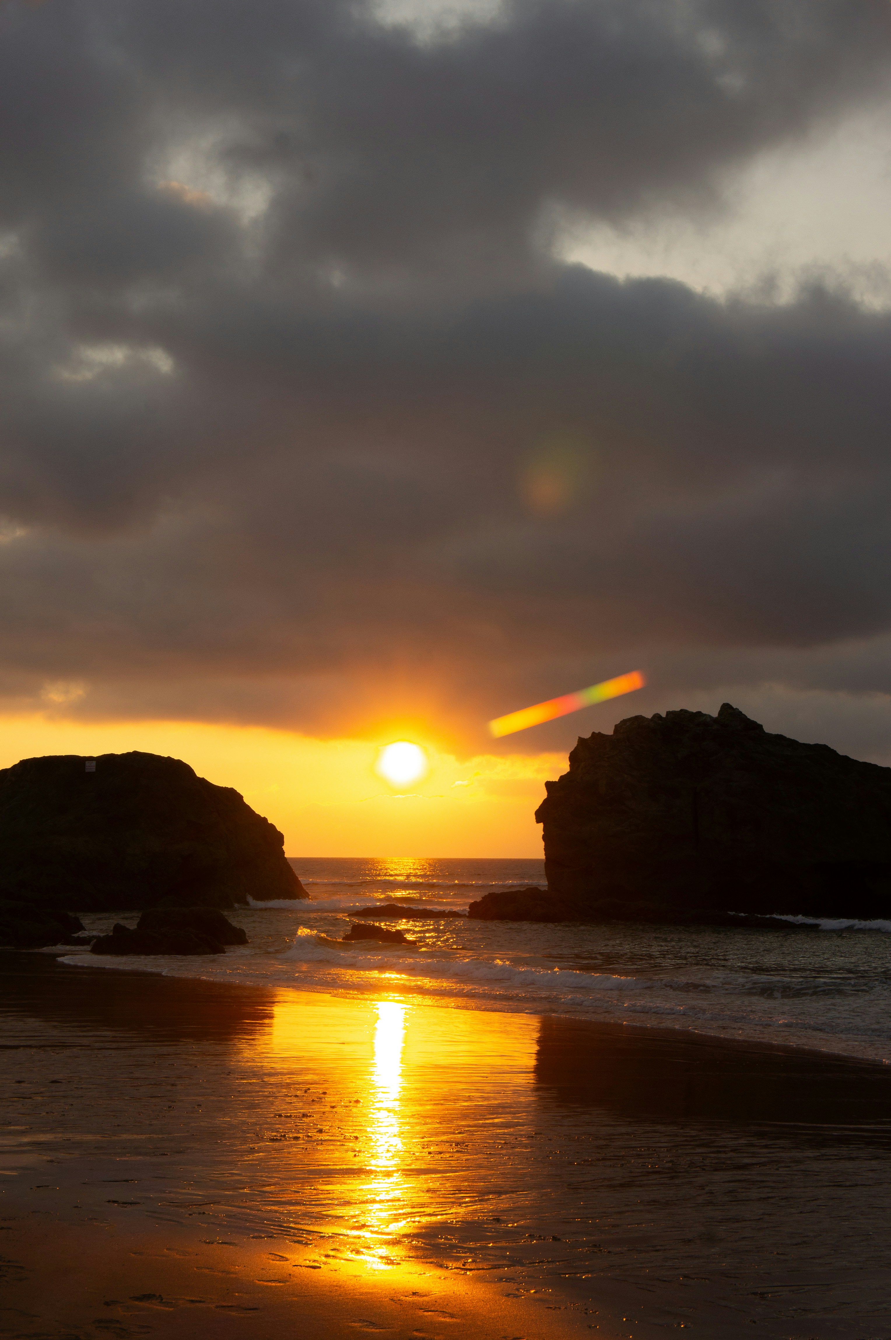 Sunlit Sea Gate: A Golden Moment Between Rocks and Shore