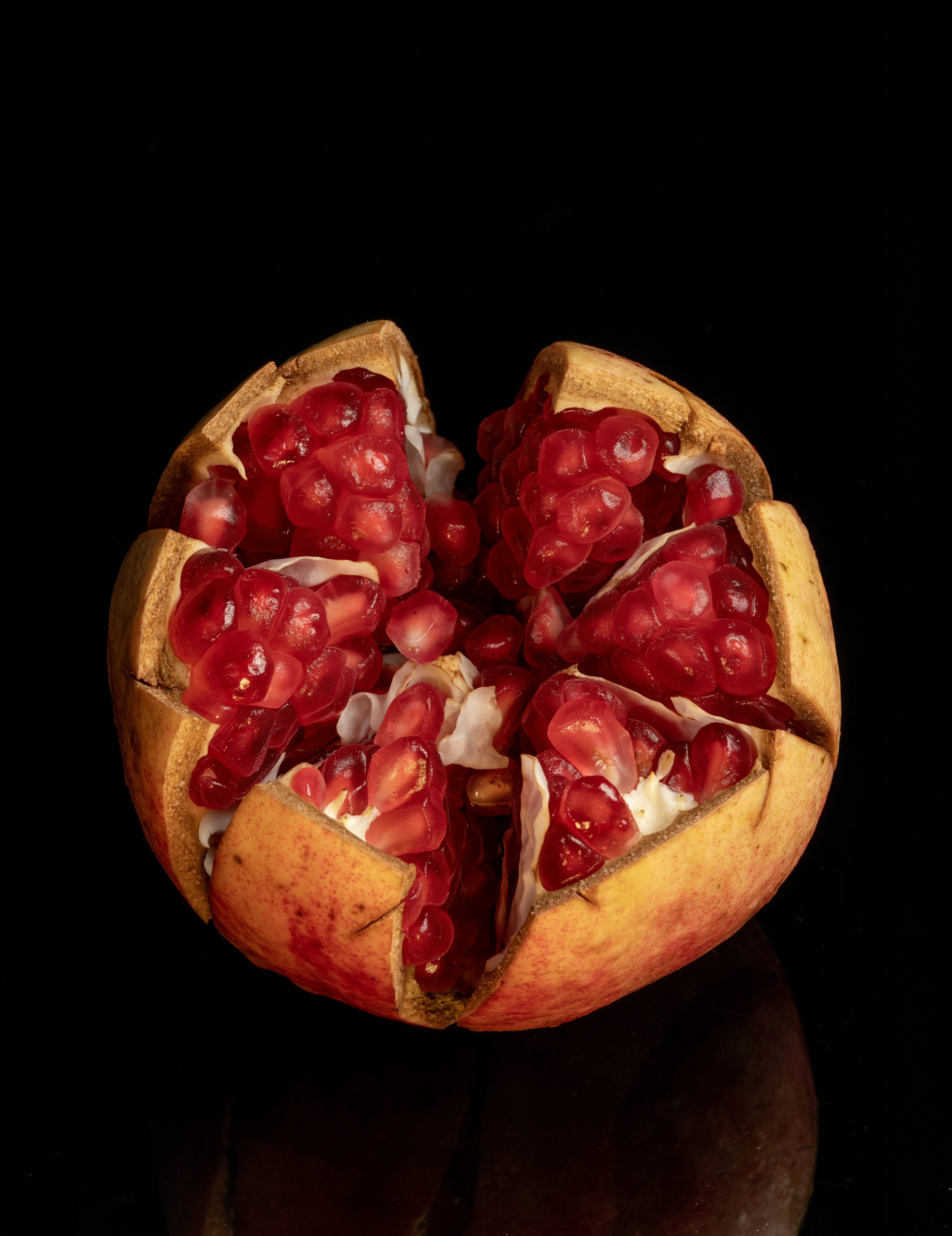 Crimson Segments: A Pomegranate Crown Resting on Black