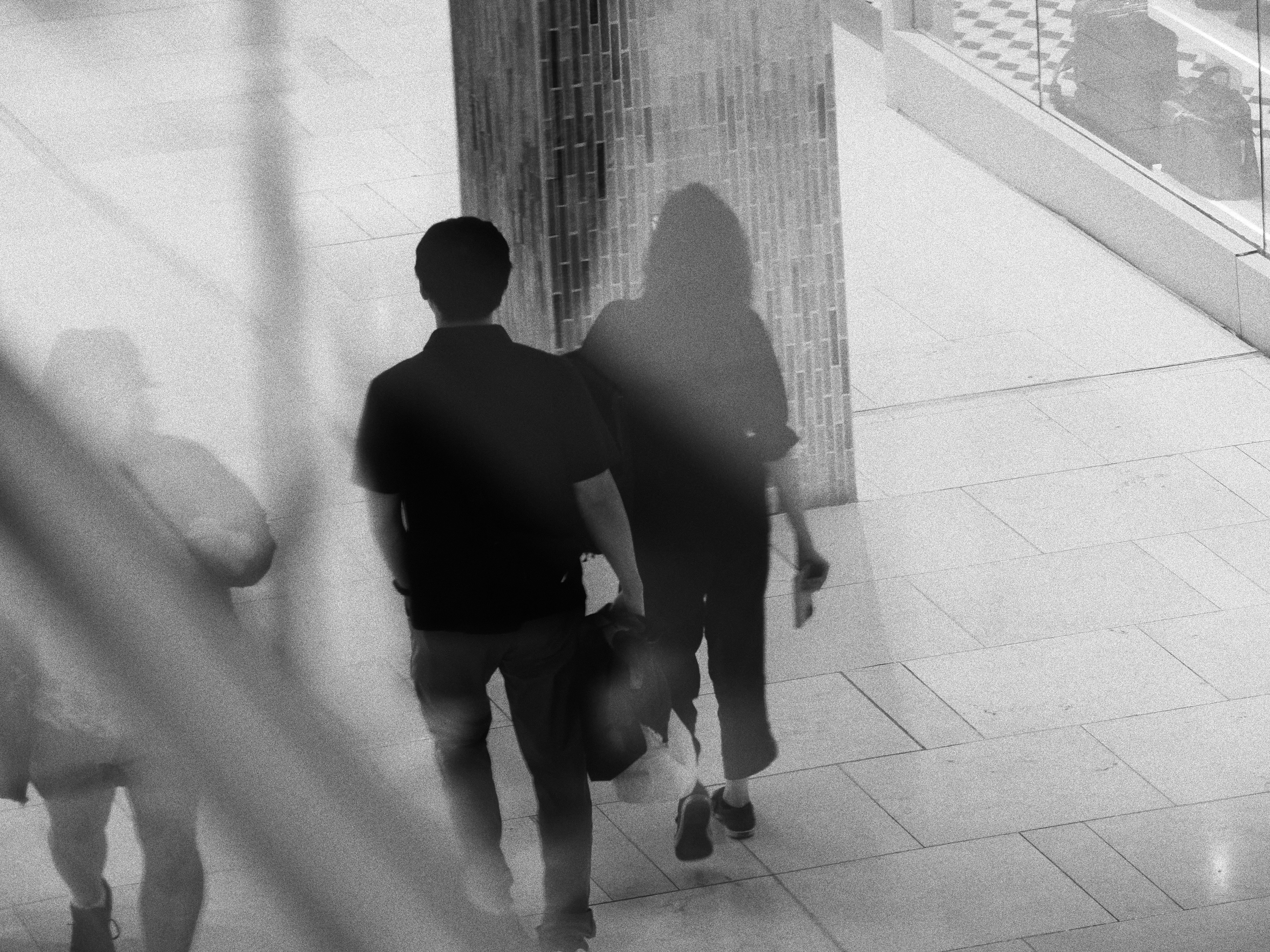 Silhouetted duo in a sunlit lobby: a quiet moment among strangers