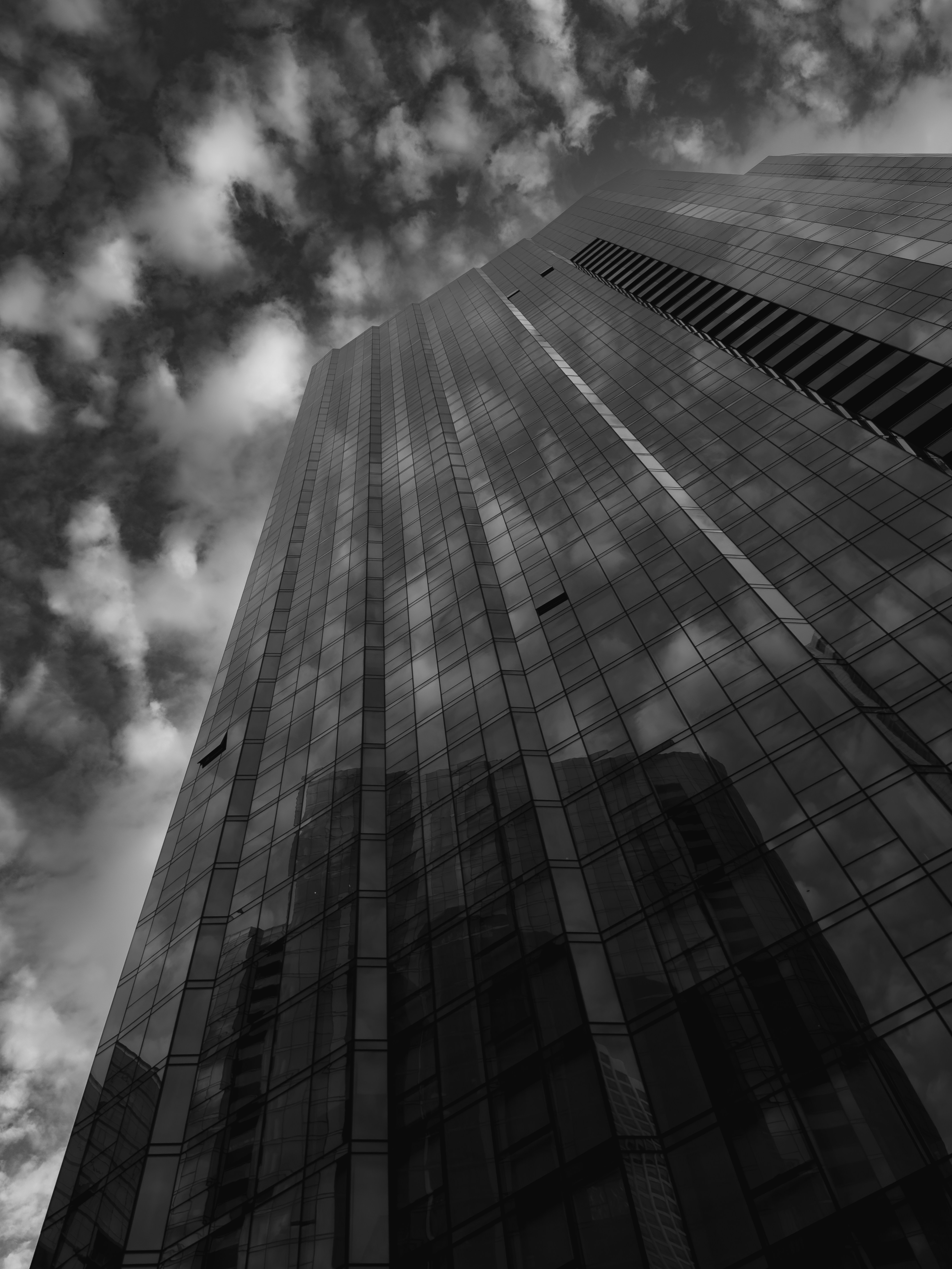 Skyscraper Portrait: A Tilted Glass Monolith Threaded with Light and Cloud
