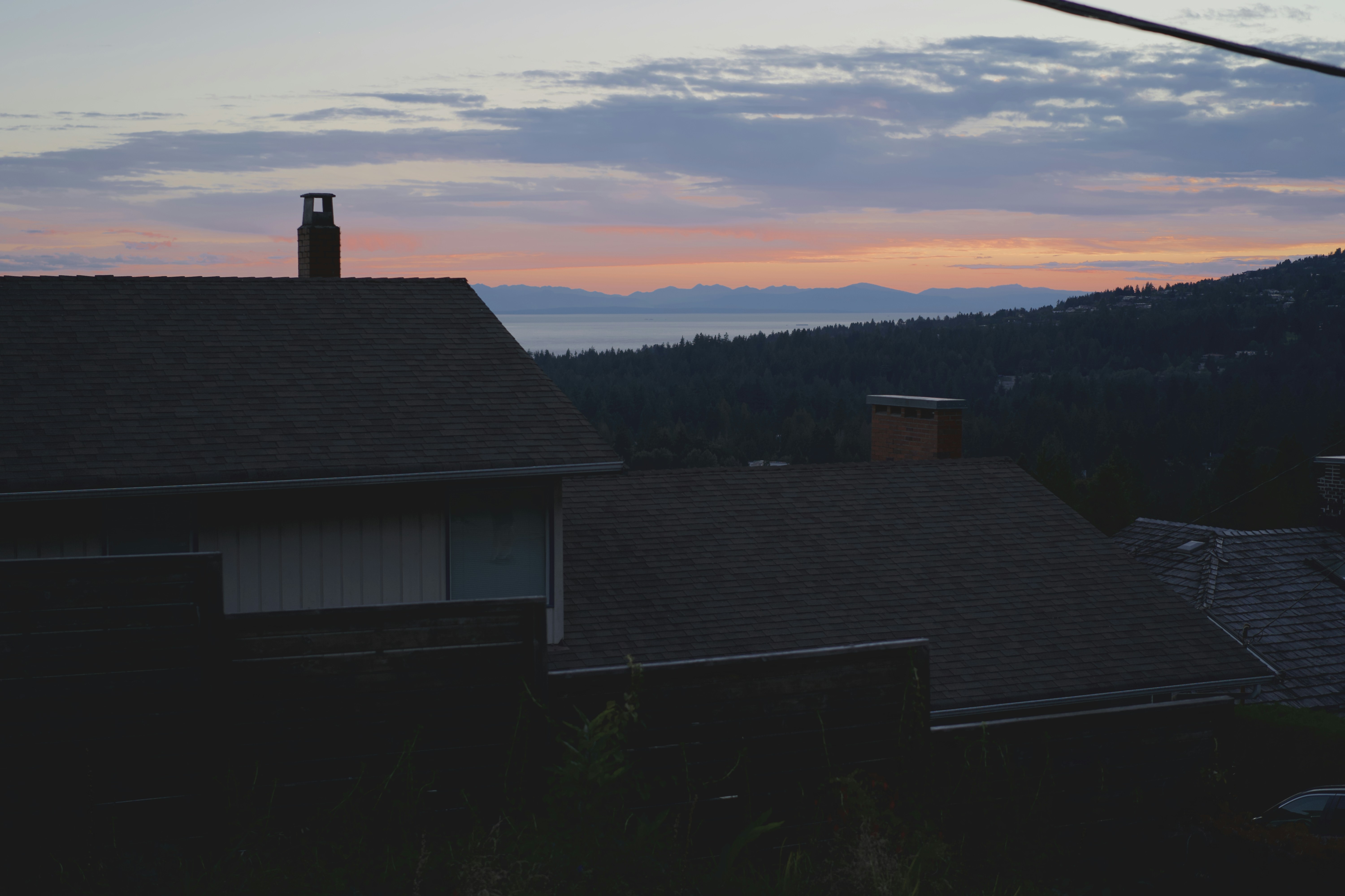 Sunset Over Quiet Ridge: Suburban Roofline Framed by Distant Horizon