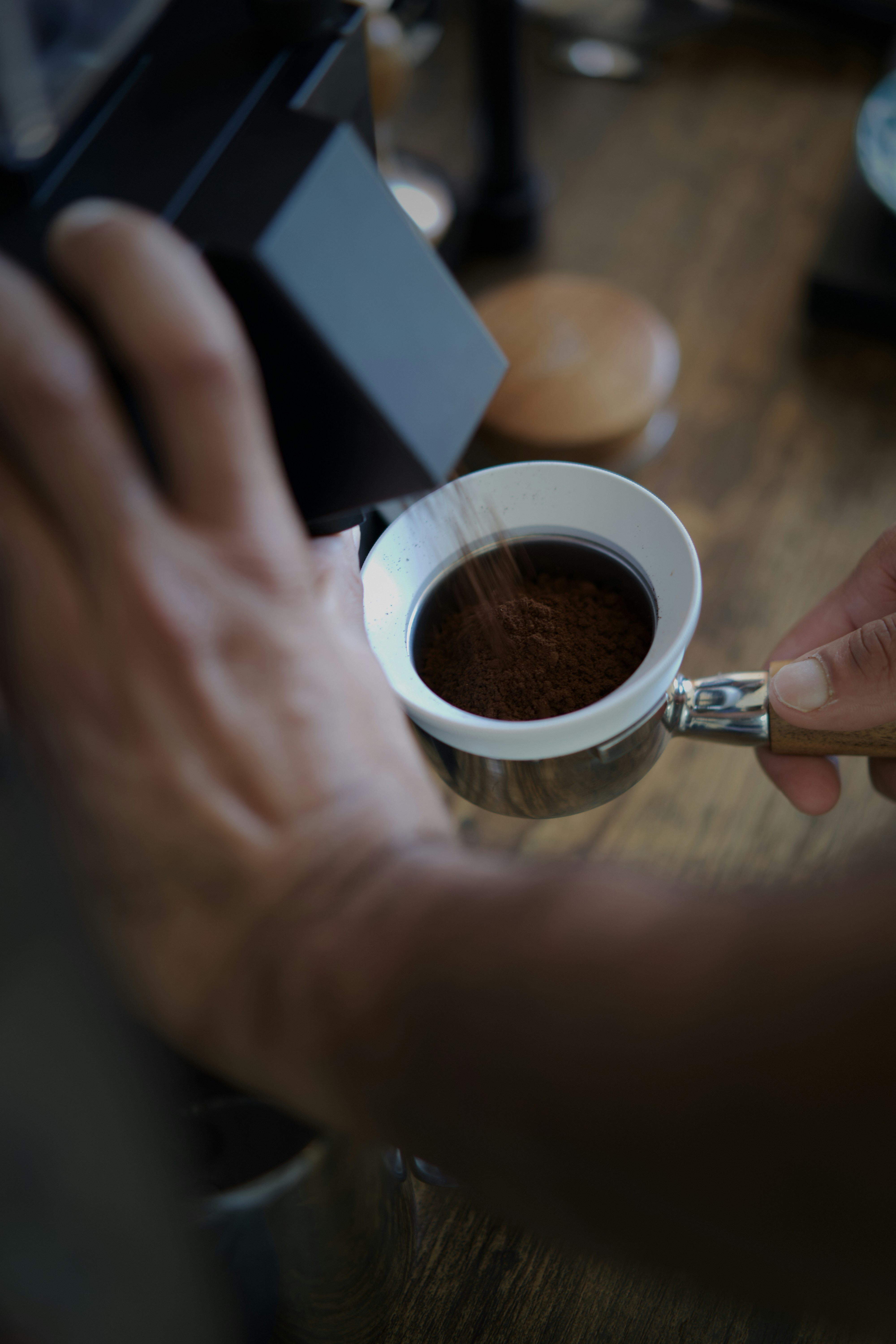 Grounded Brew: Close-Up of Espresso Extraction in a Barista’s Hands