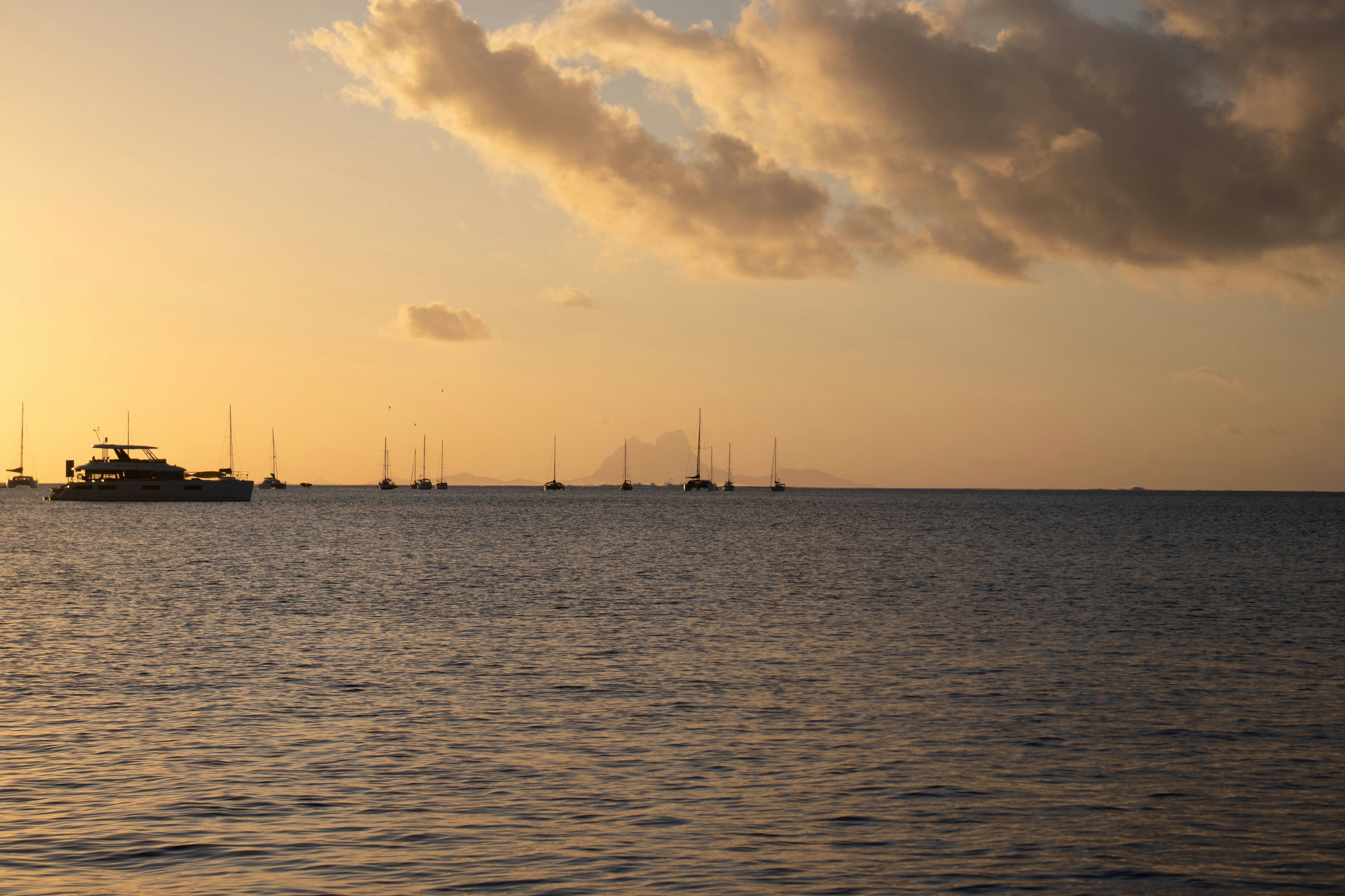 Horizon Glow: Boats at Dusk Over Quiet Seas