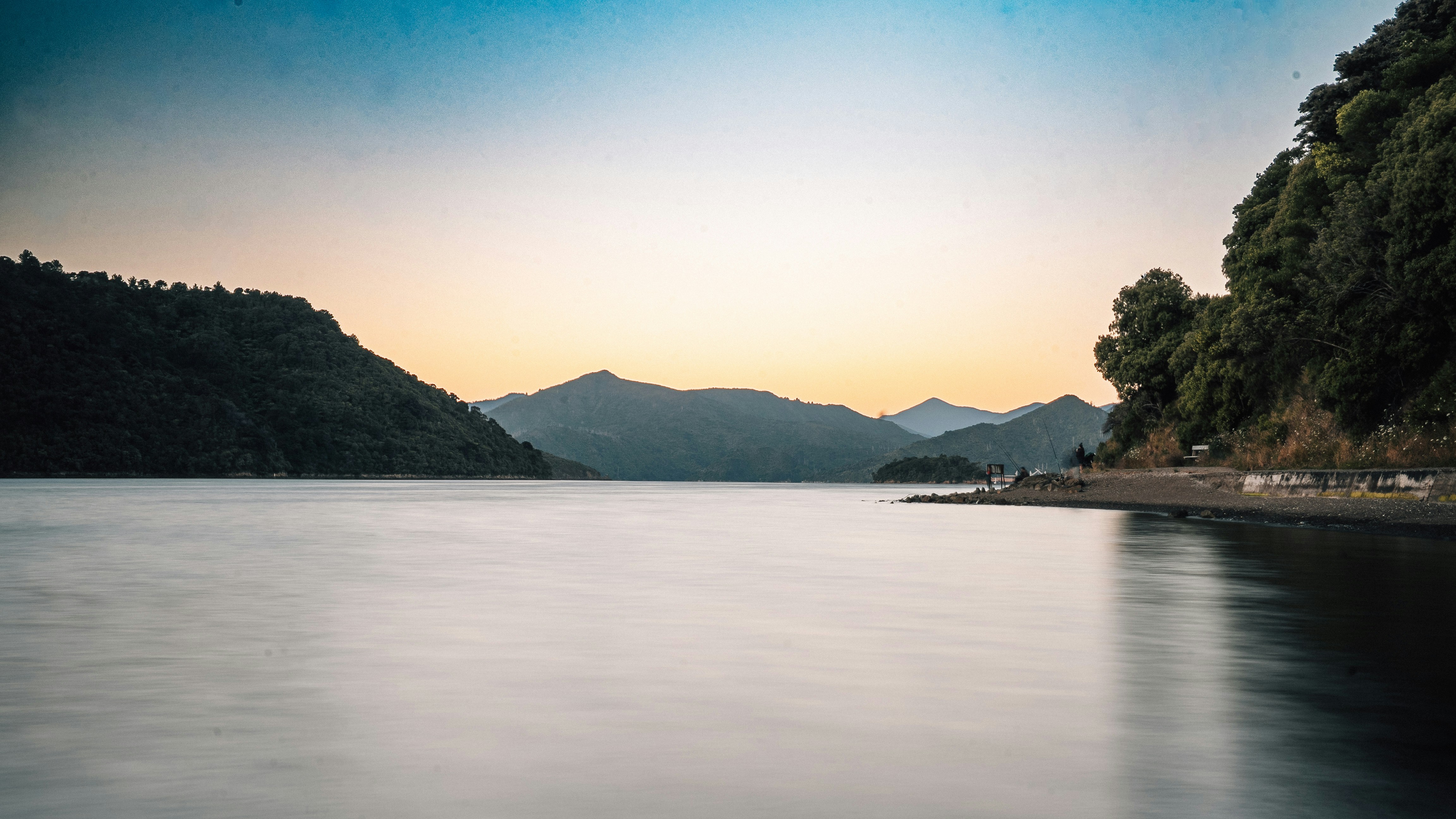 Quiet Confluence: Sunset Over a Serene Mountain-Walled Lake