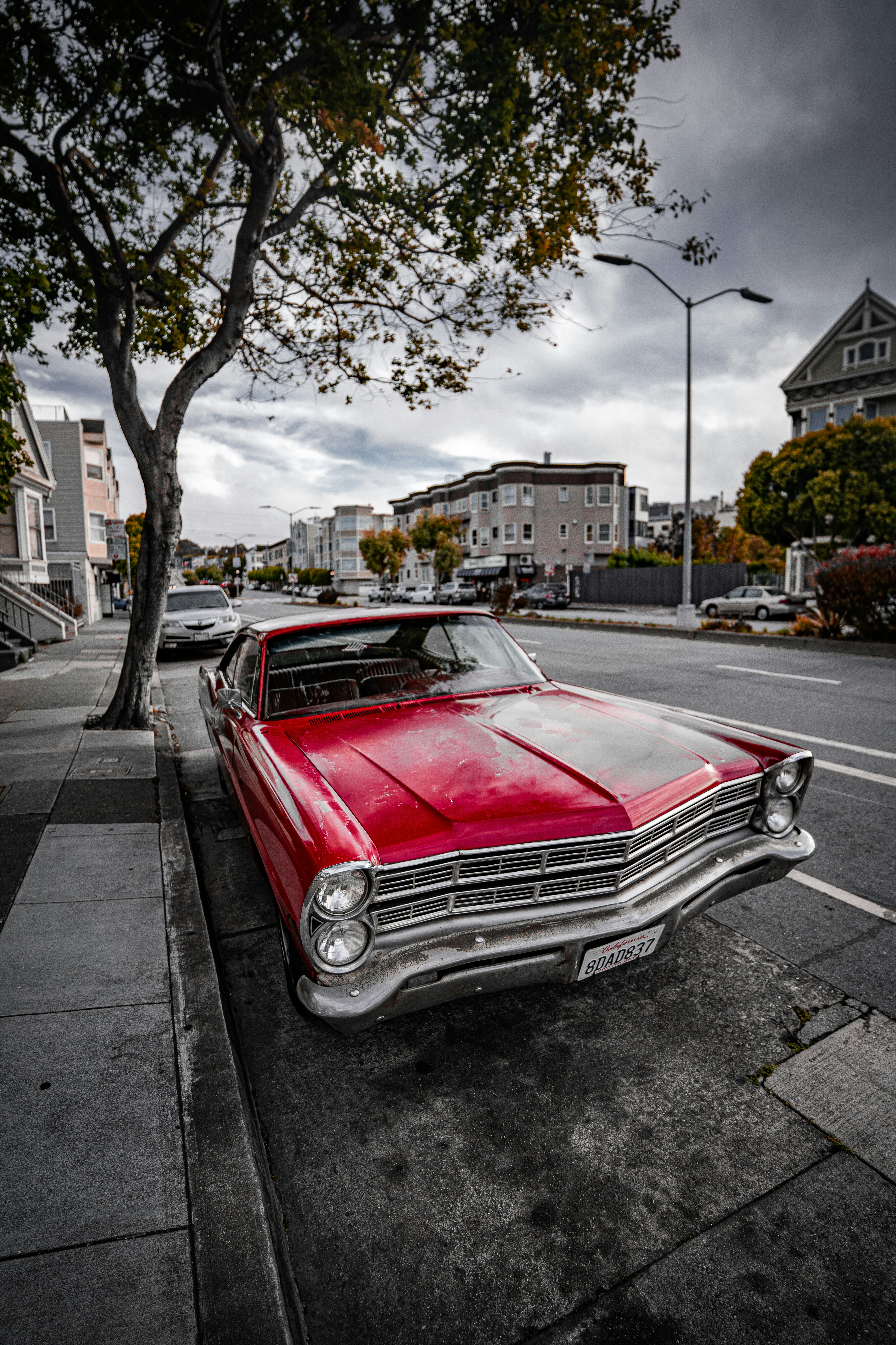 Crimson Classic: A 1960s Muscle Car Resting on a City Street