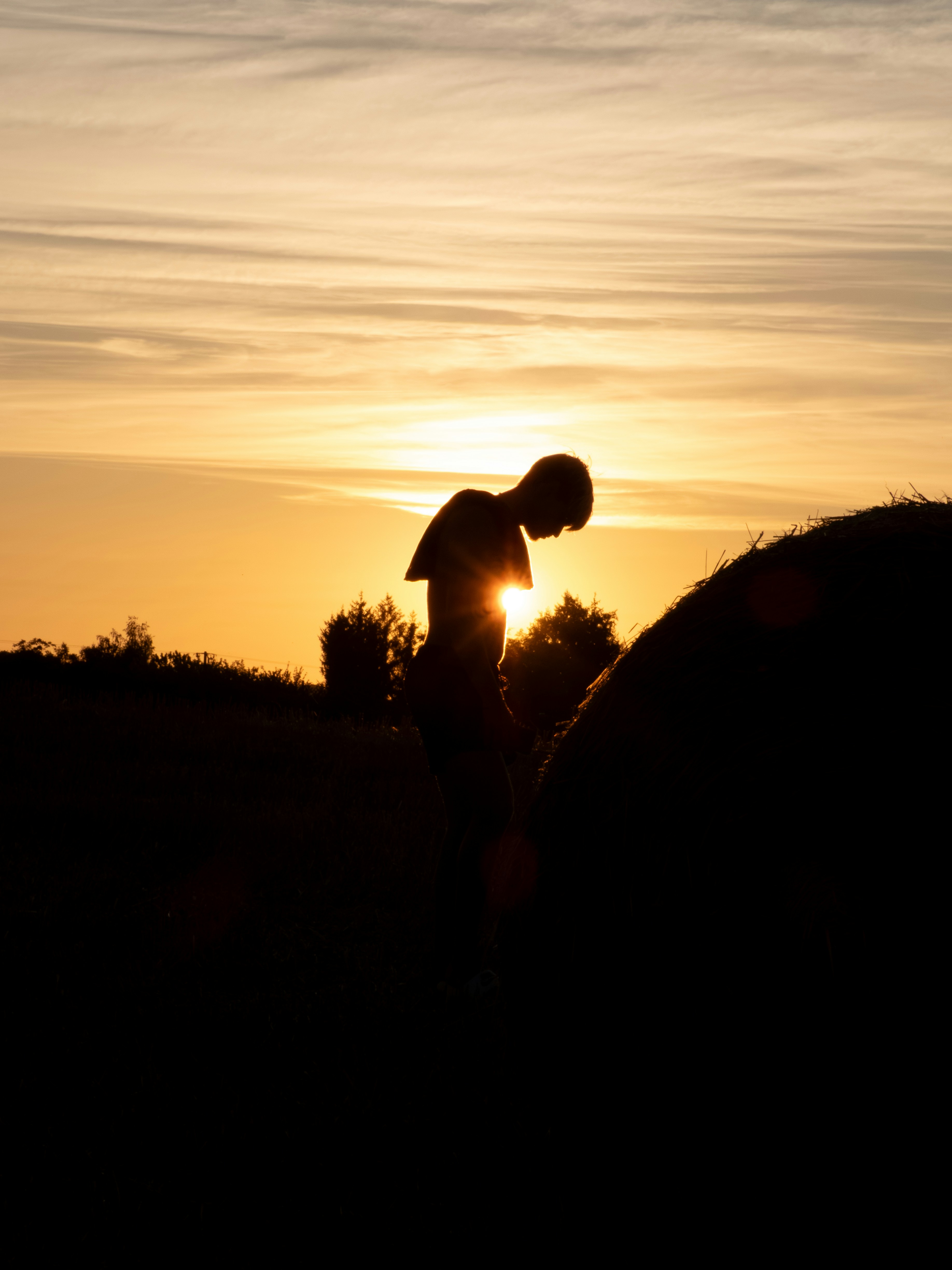 Silhouette at Sundown: A Quiet Moment with the Hay Bale