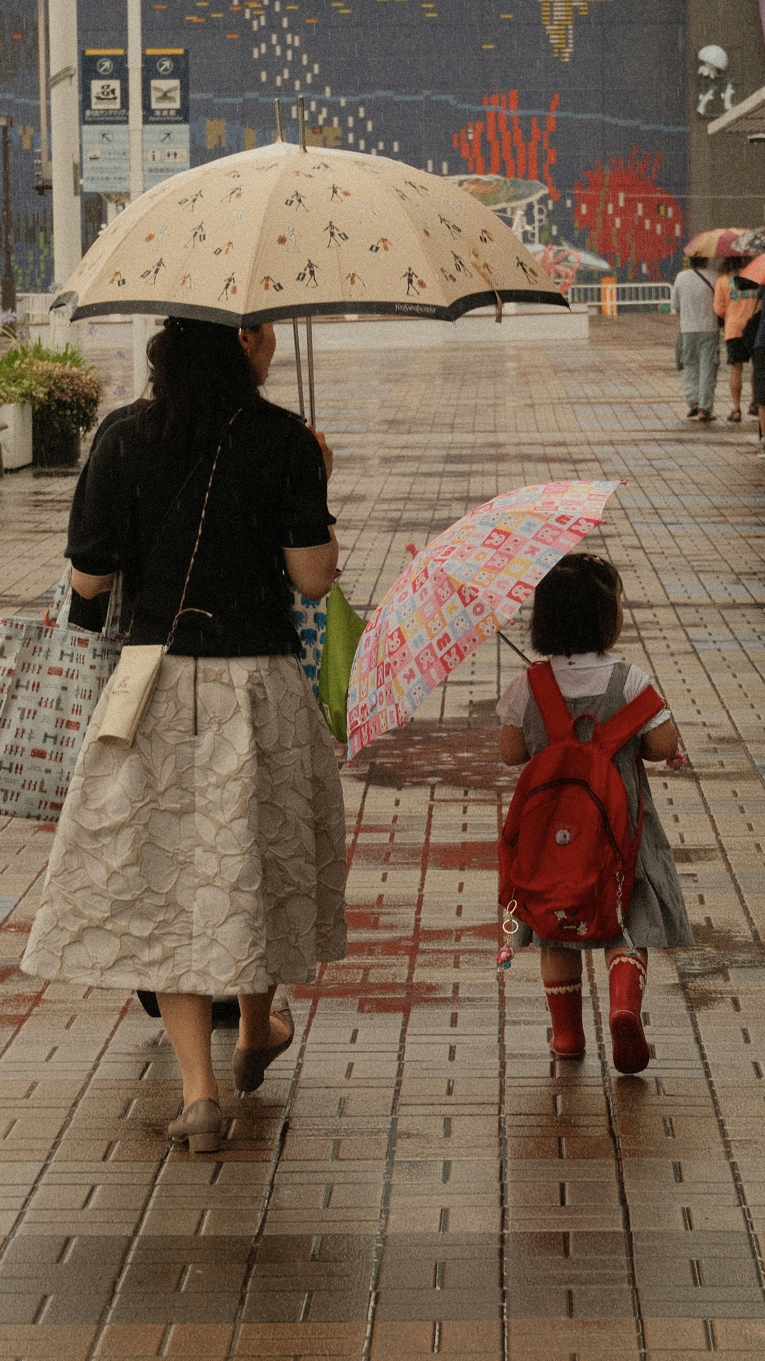 Umbrella-guided Path: A Mother and Child Walk in Rainy City Light