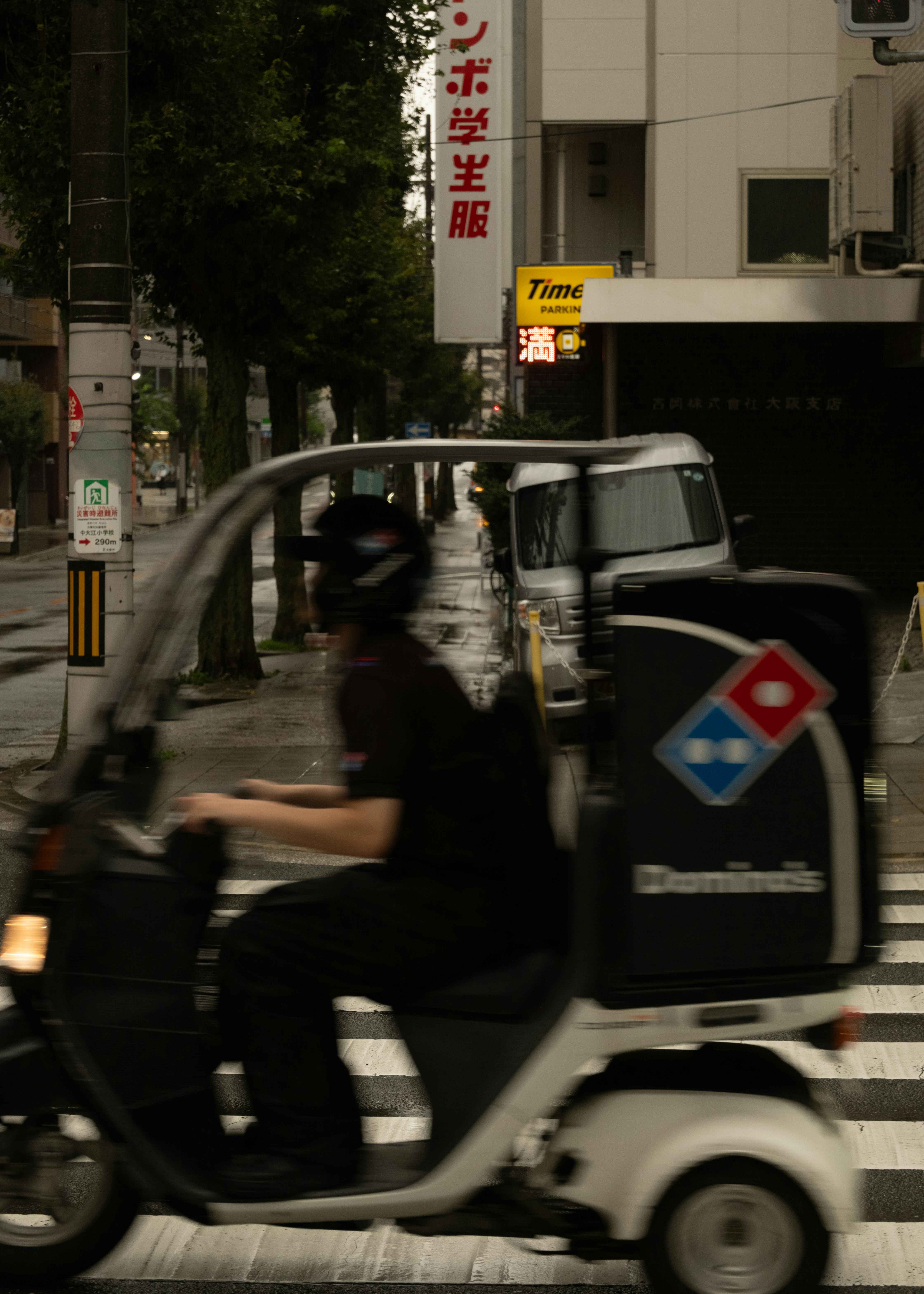 Scooter Courier Whirl on a Rainy Tokyo Street