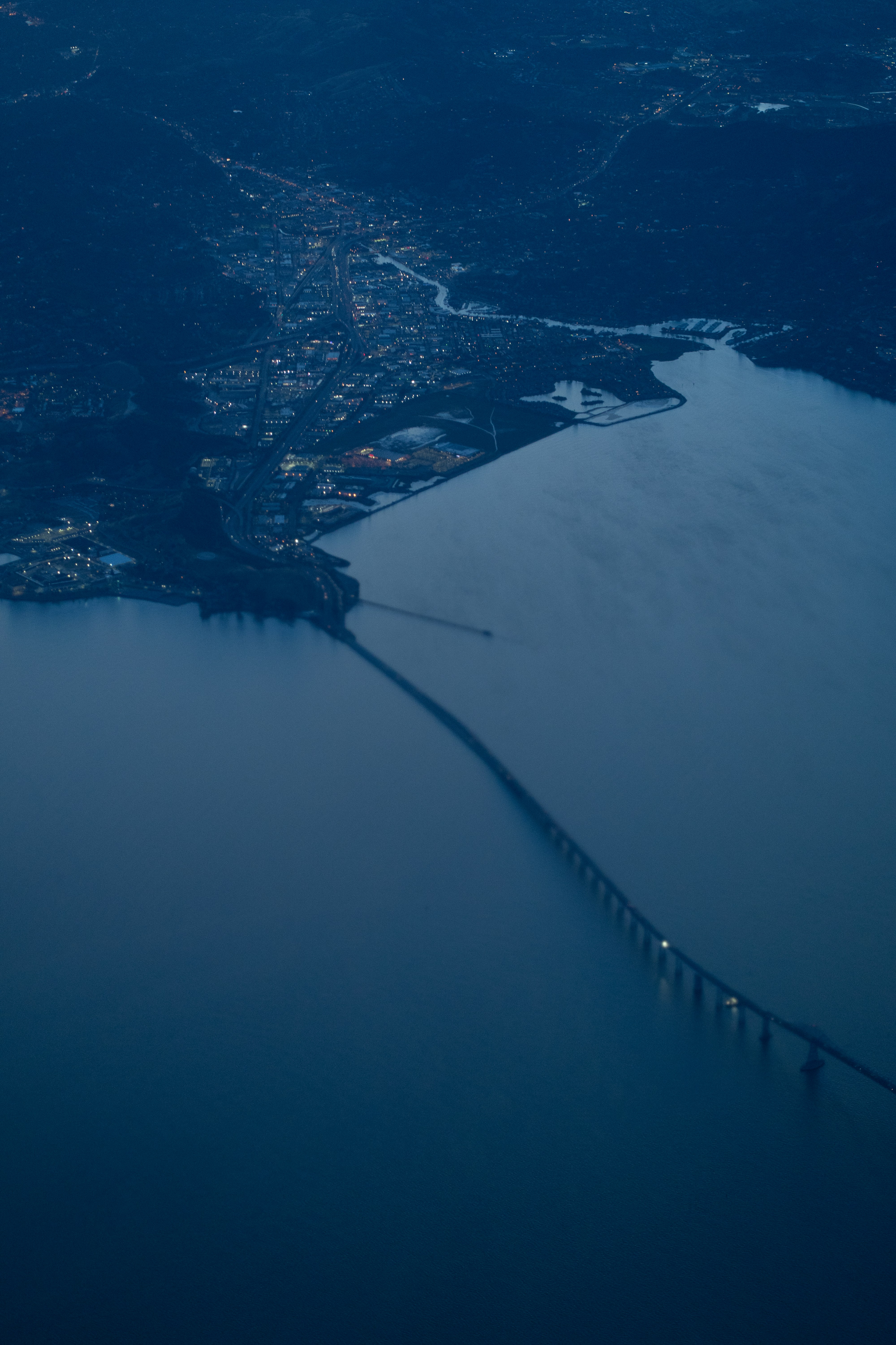 Coastal Cityscape: Aerial View with Pier Extending into Calm Harbor