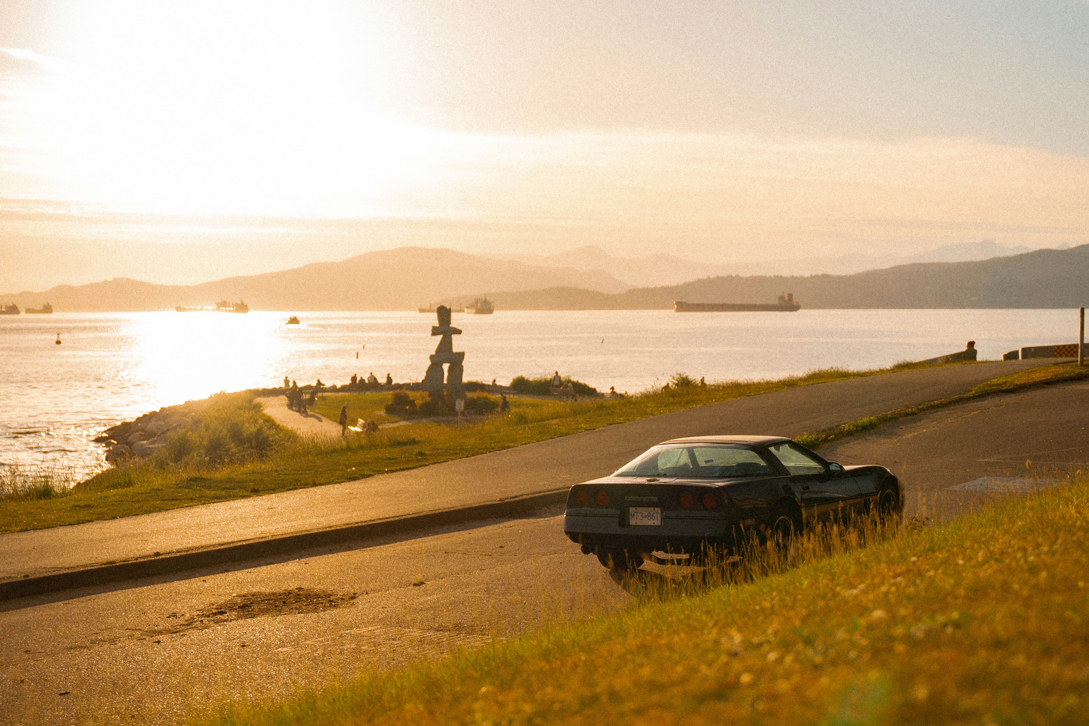 Sunlit Shoreline with Vintage Car at Golden Hour