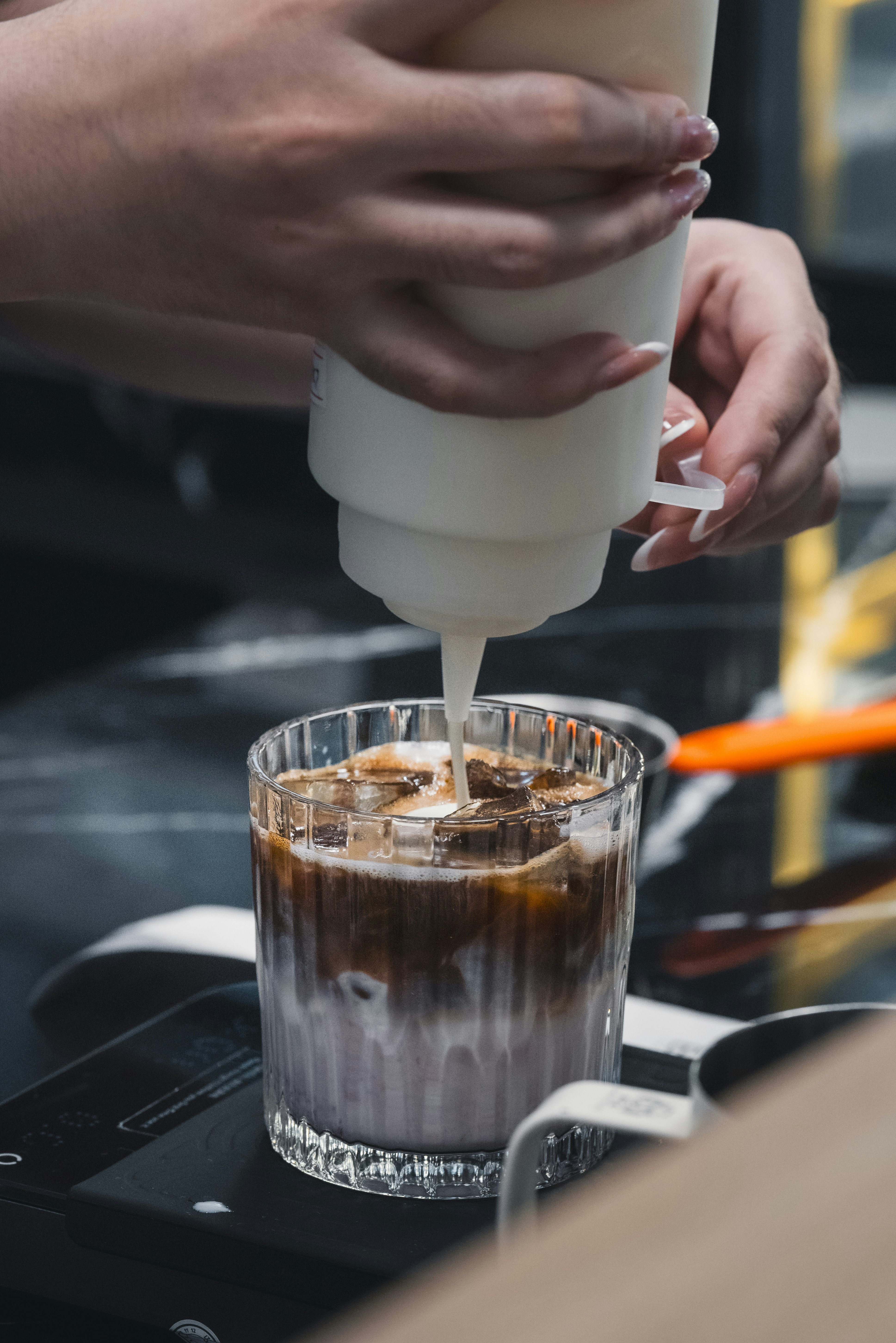 Pouring Precision: A Creamy Thread of Coffee on Ice