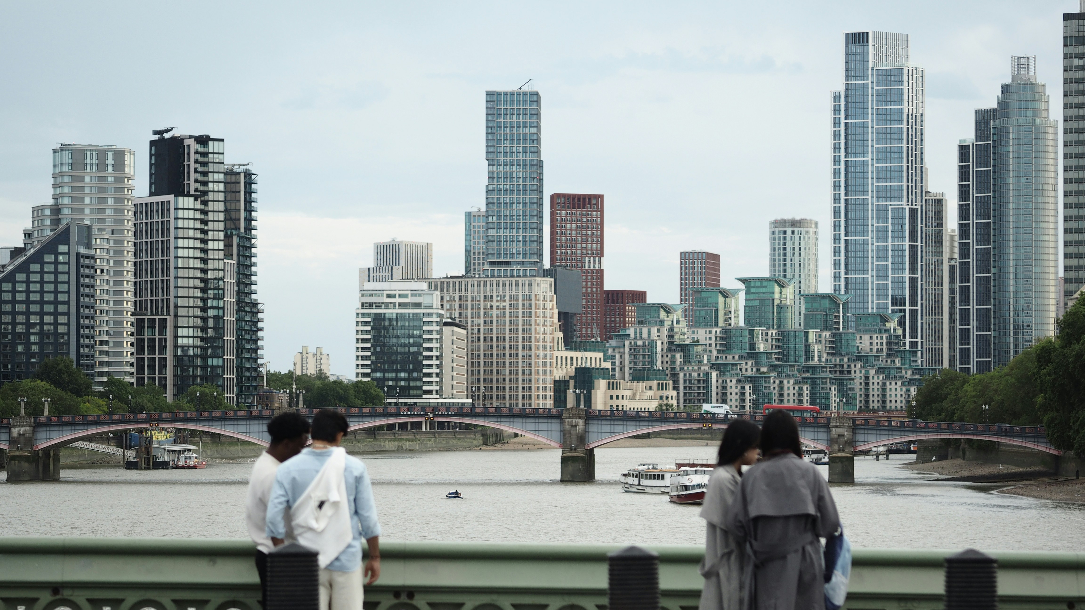Riverside Gaze: Pedestrians Watch the City Skyline from the Docks