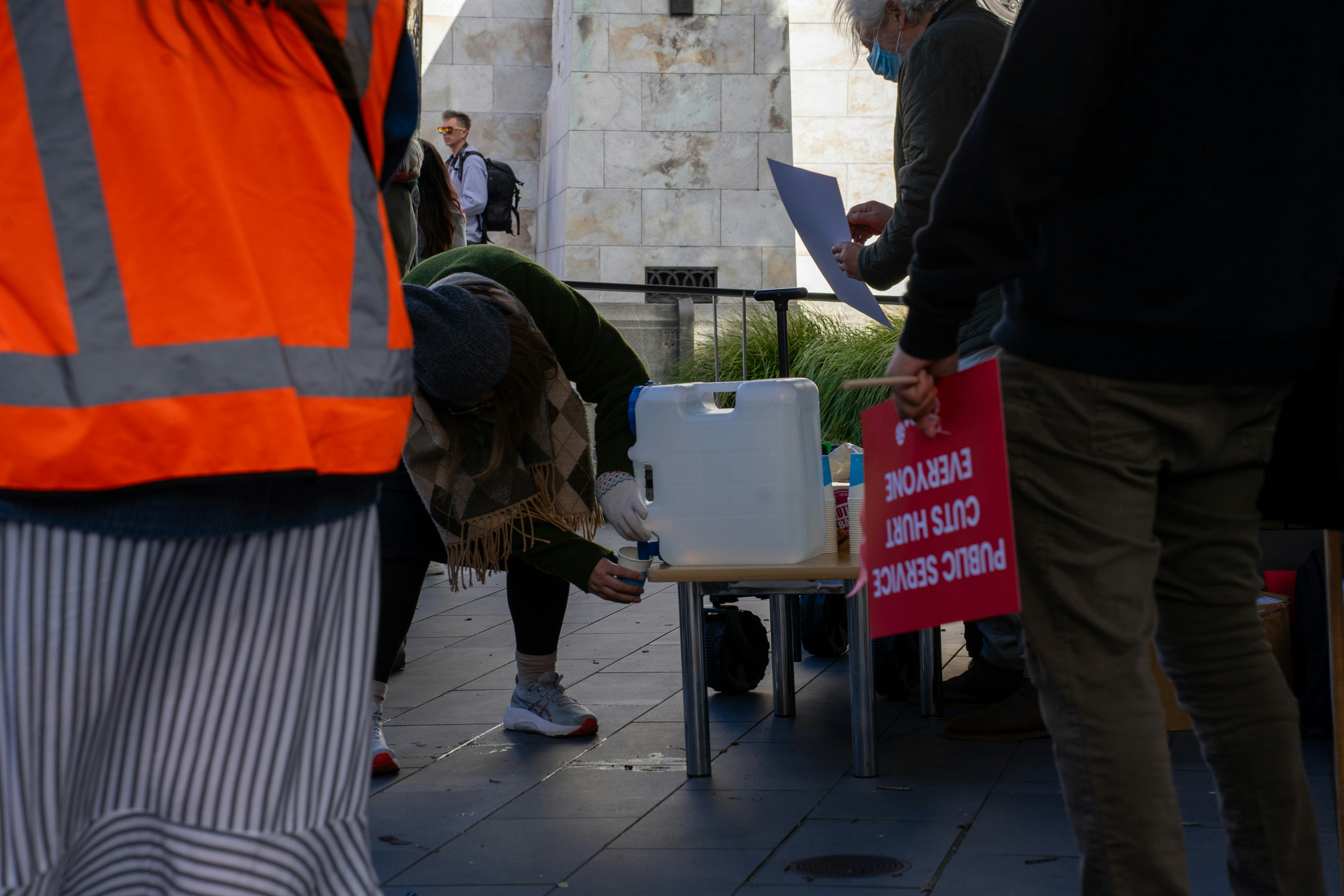 Street Floor Assist: Volunteers and a Water Container at a Civic Event