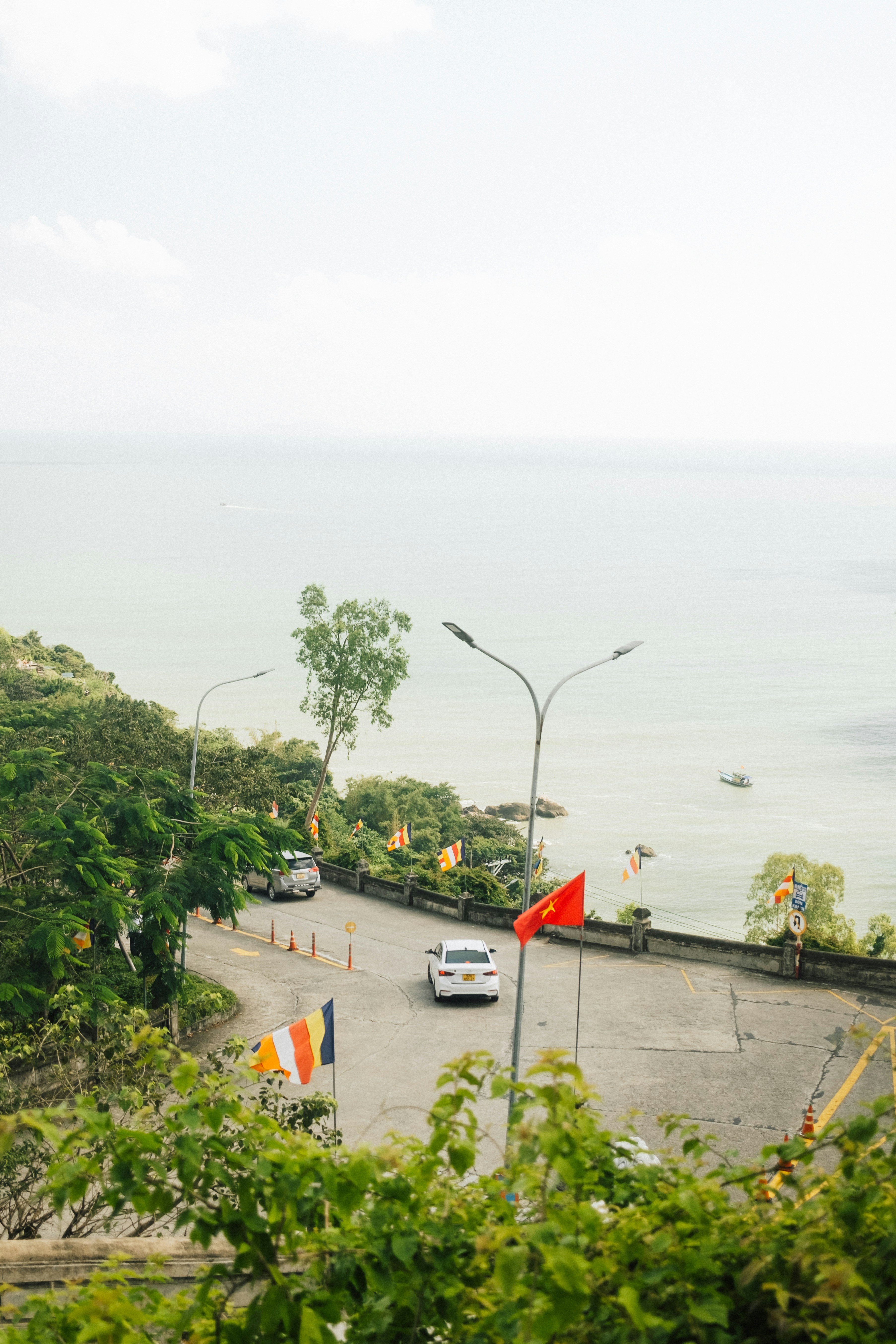 Coastal Terrace: Flags, Cars, and Ocean Vista