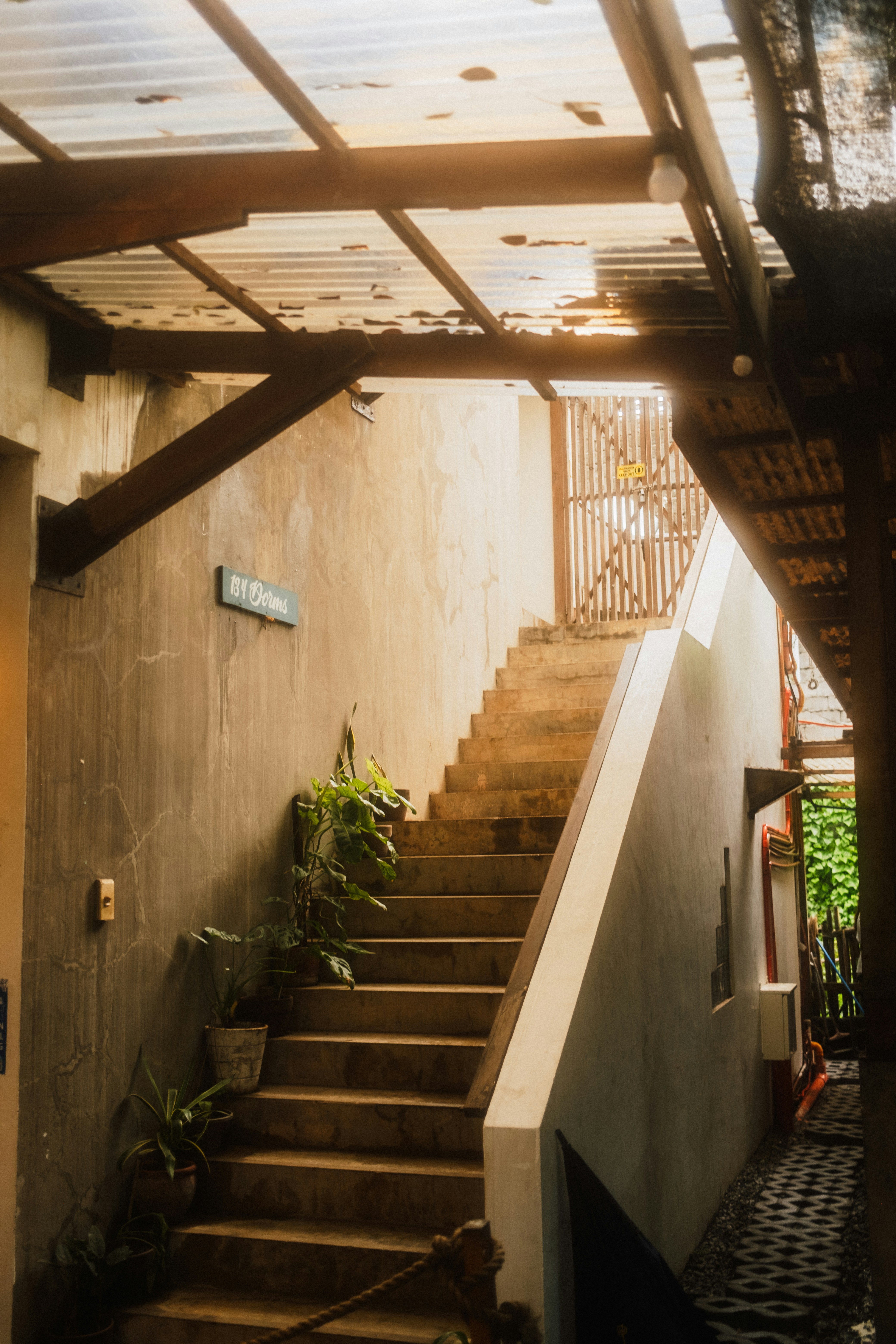 Sunlit Staircase Through a Corrugated Glass Canopy