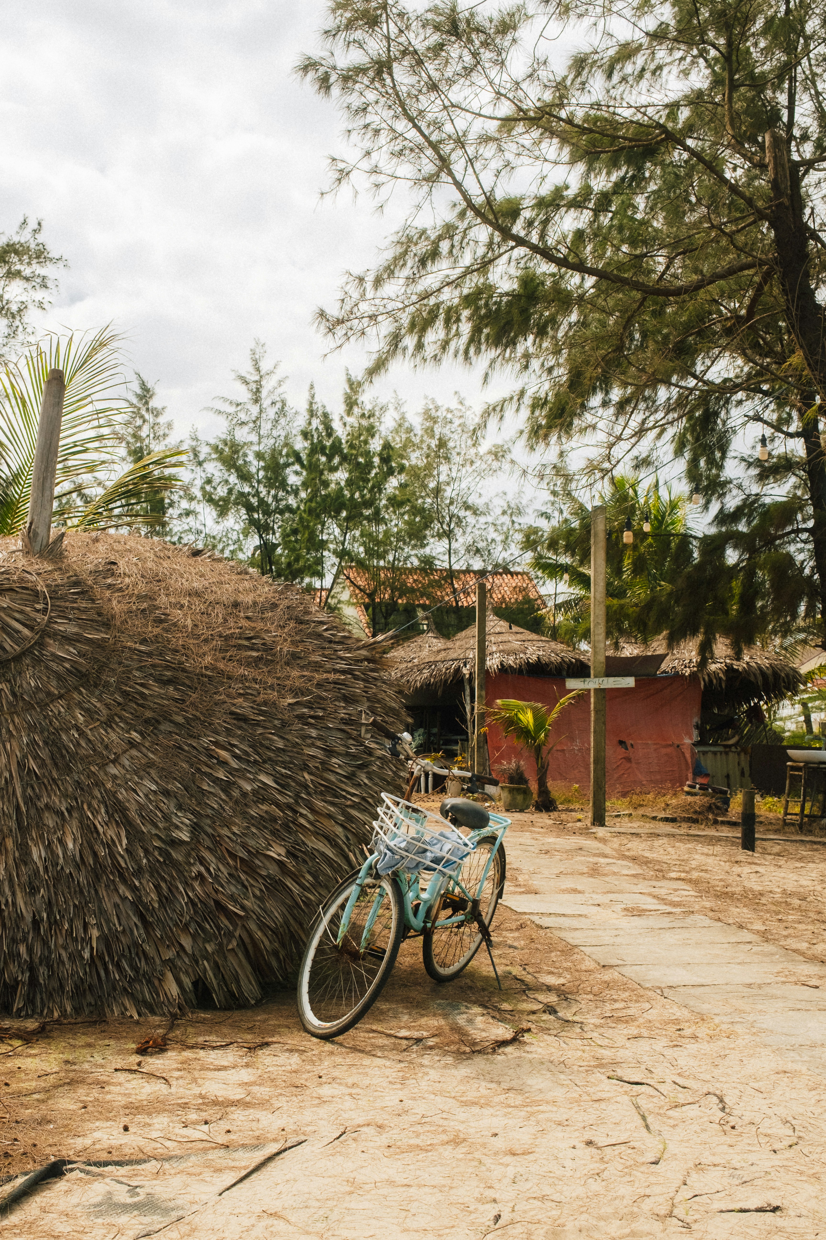 Azure Bicycle by the Thatch Hut in a Tropical Village