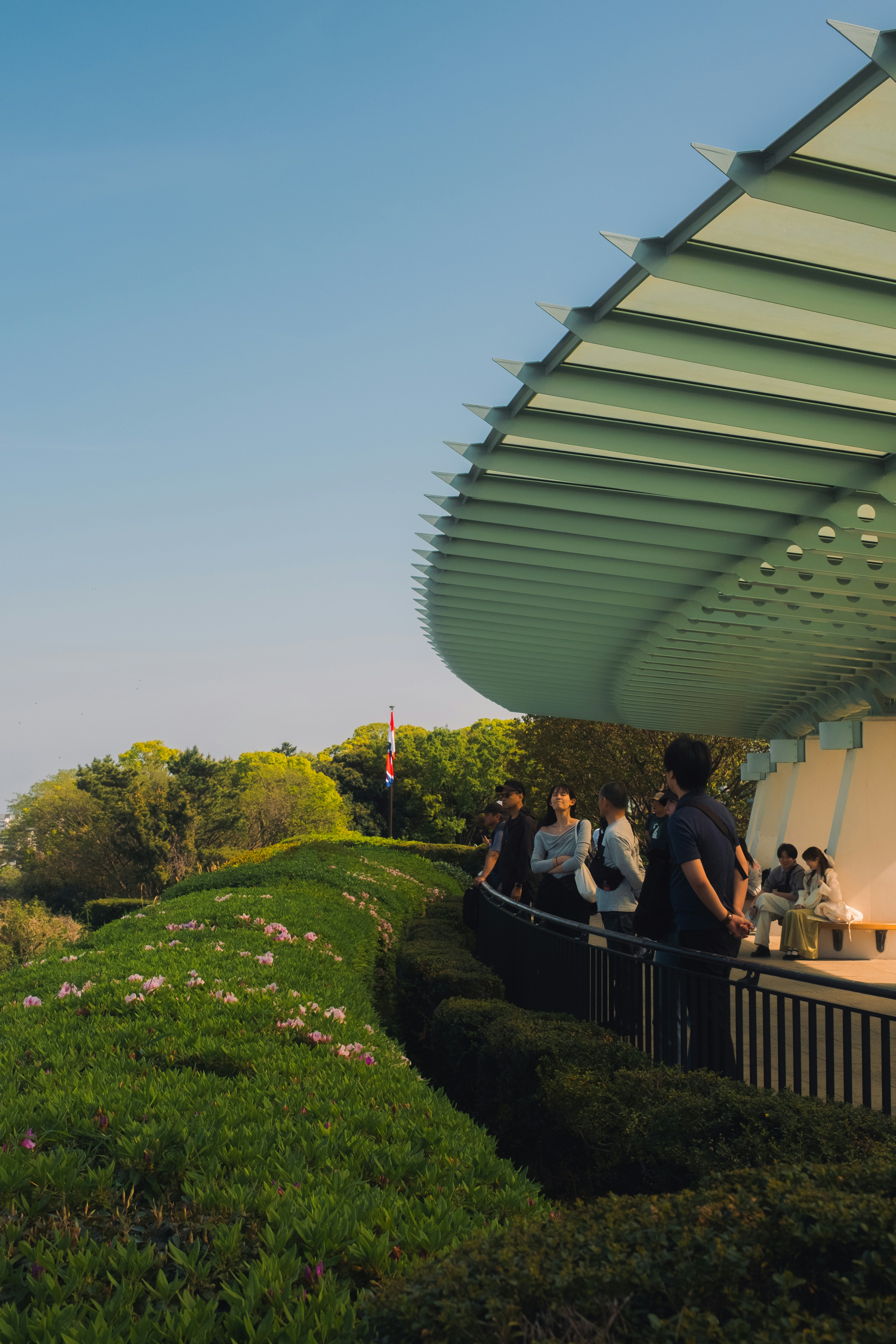 Overhang of engineered shade: A corridor of visitors beneath curved ribs