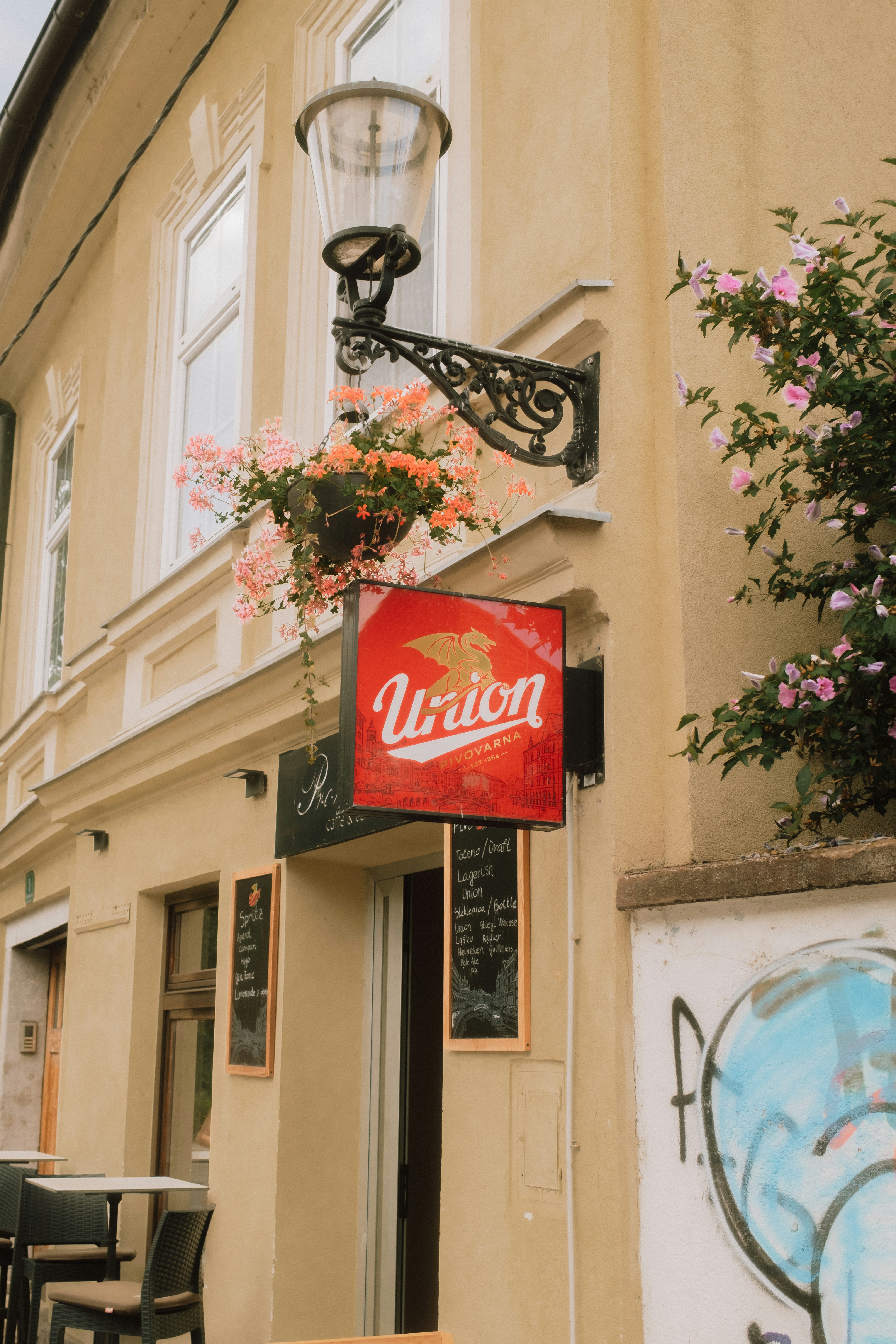 Red Sign, Warm Facade: A Cobblestone Street Café in Bloom
