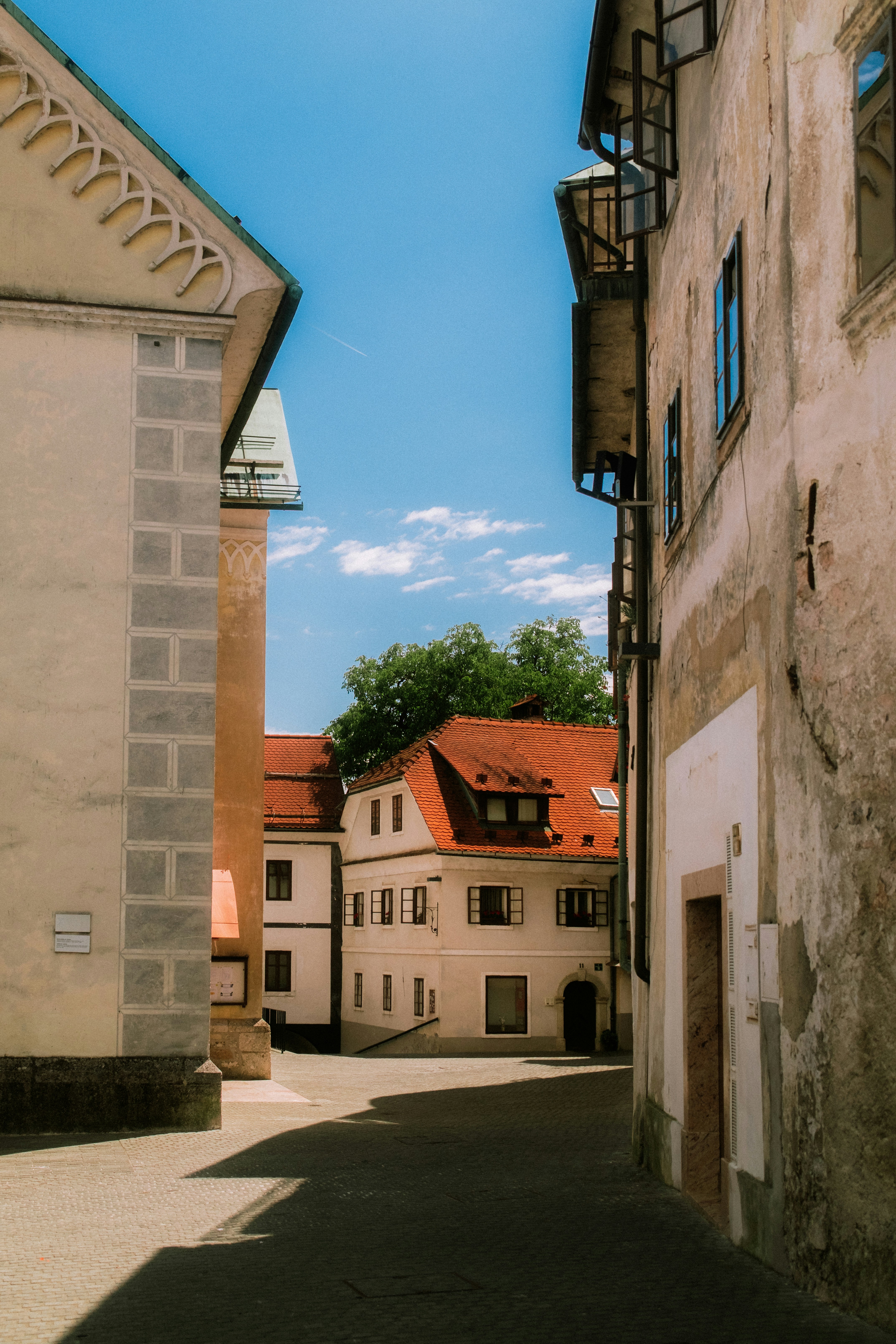 Narrow alleyway to sunlit village courtyard