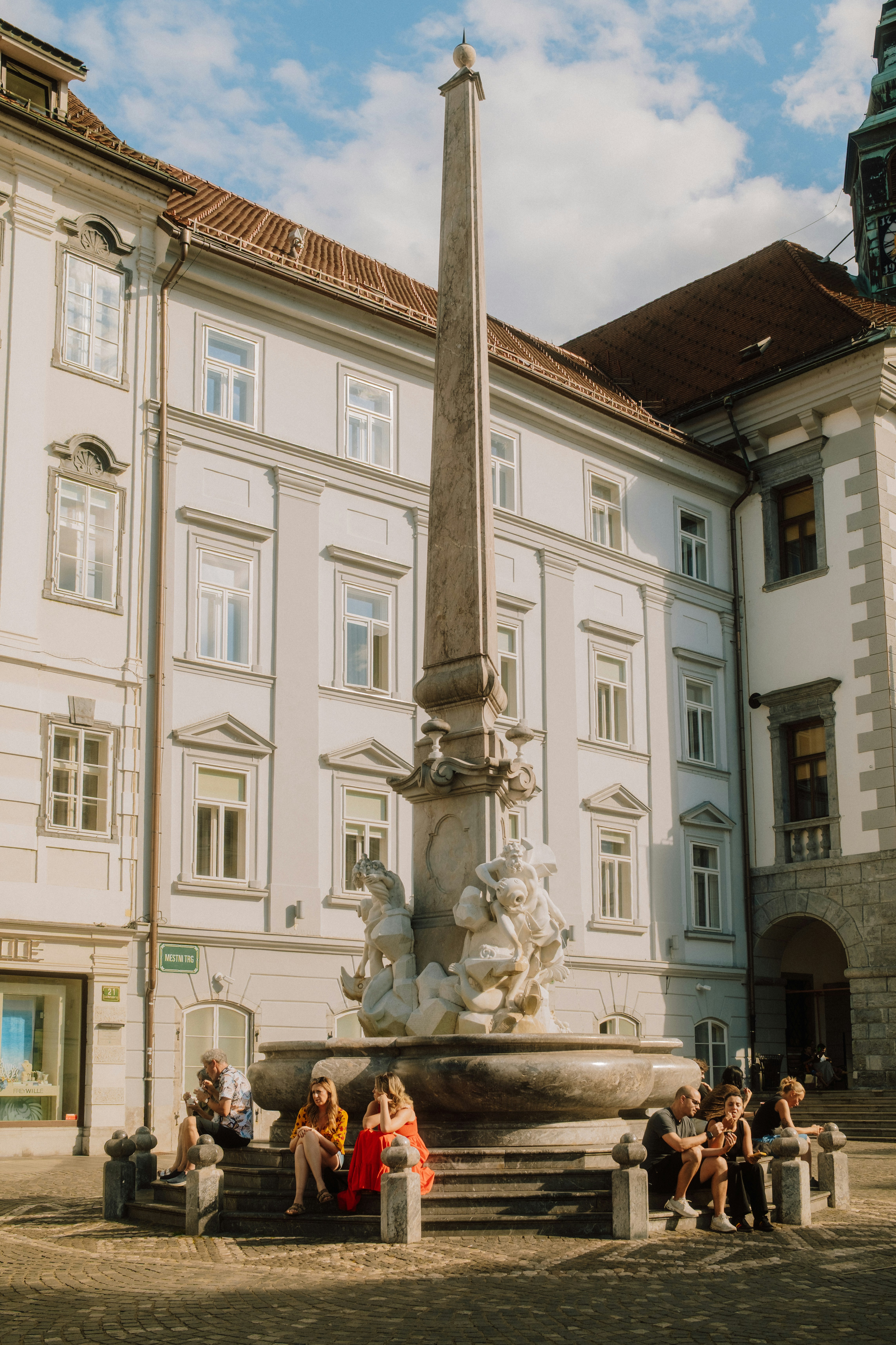 Obelisk and fountain crown: sunlit plaza with gathered visitors