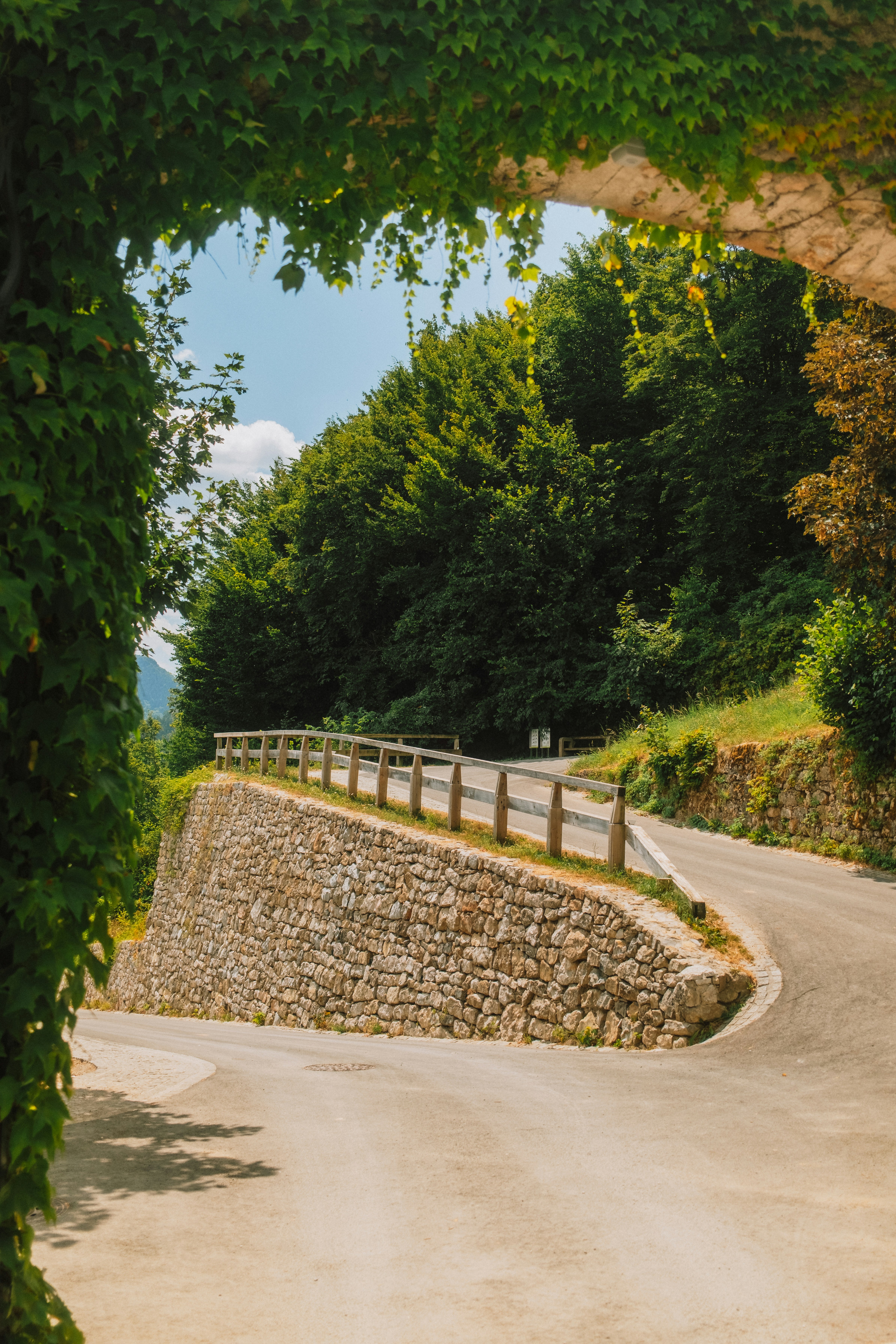 Overlooked Curve: a sunlit stone wall guides the winding road