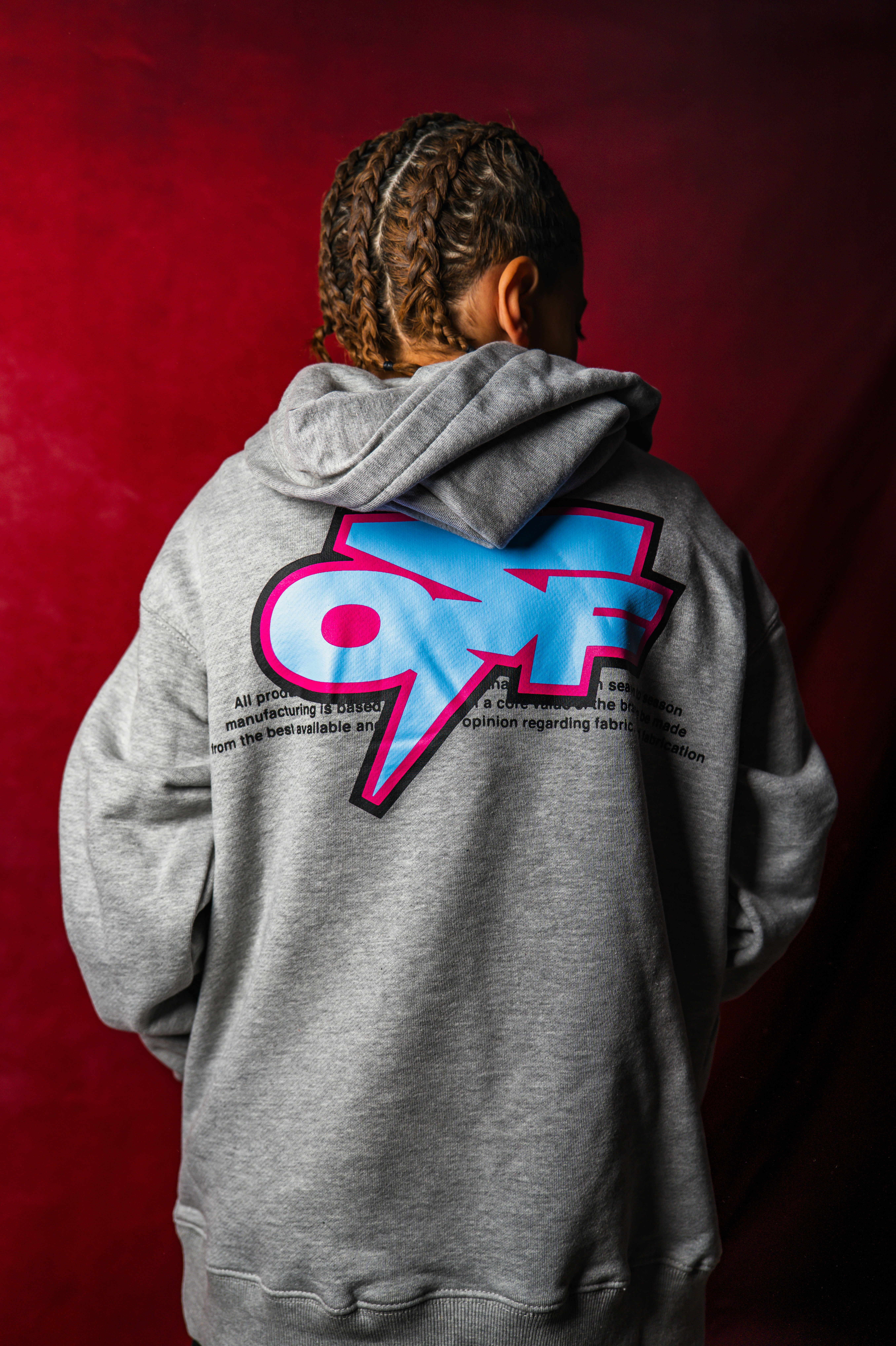 Back View with Neon Logo: A Hoodie Portrait Against a Crimson Backdrop