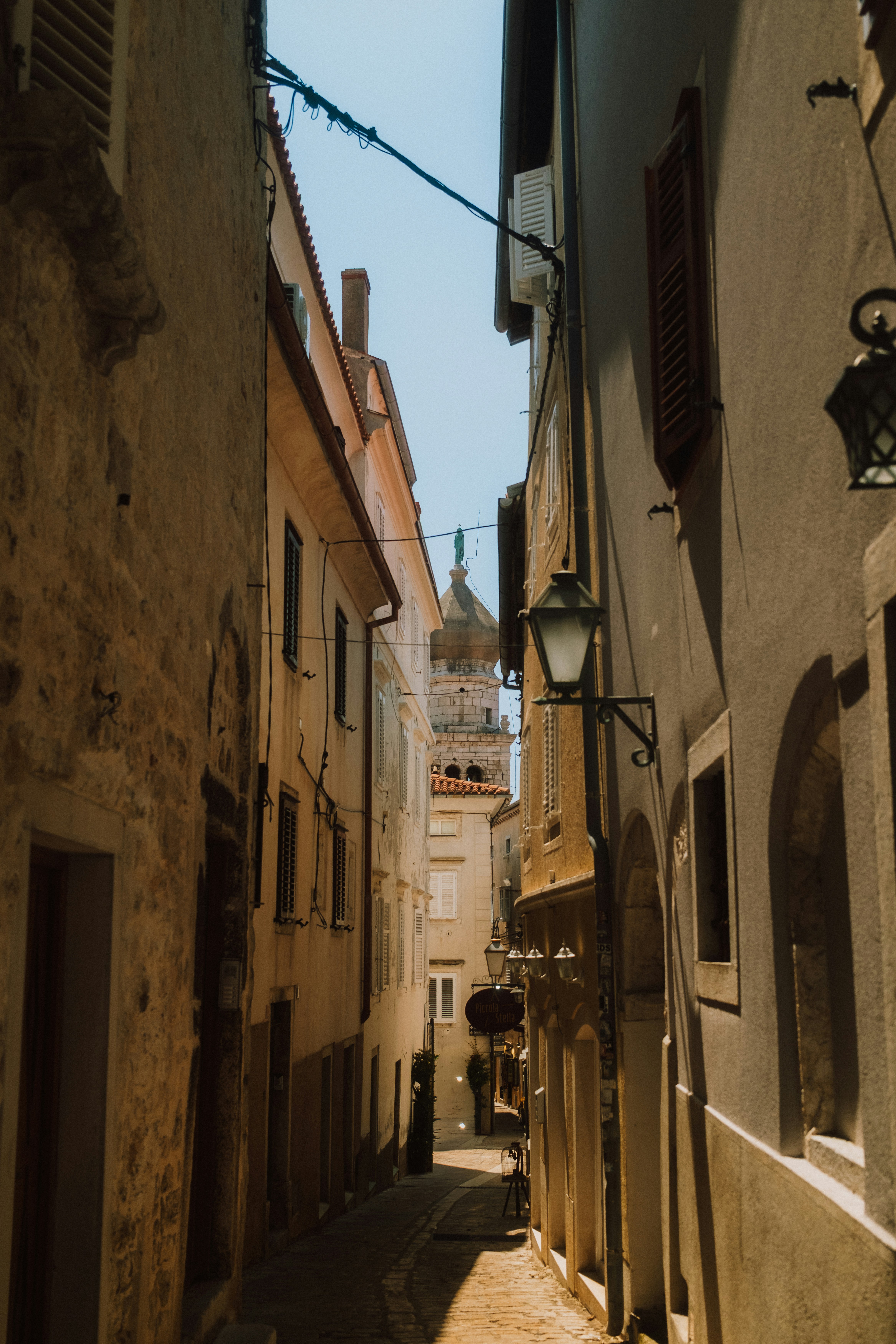 Cobbled Lane Toward a Bell Tower