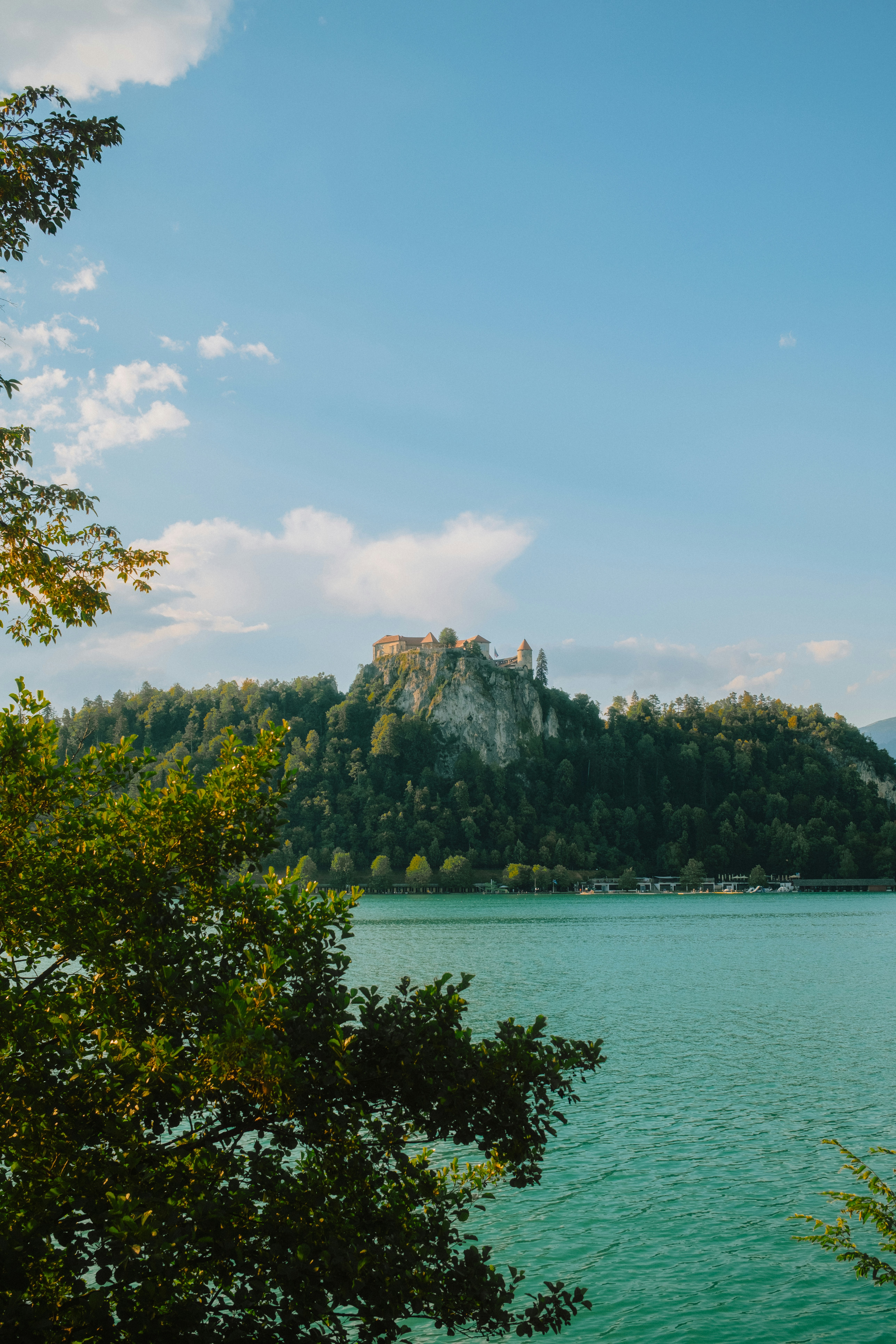 Castle atop the hill overlooking the emerald lake
