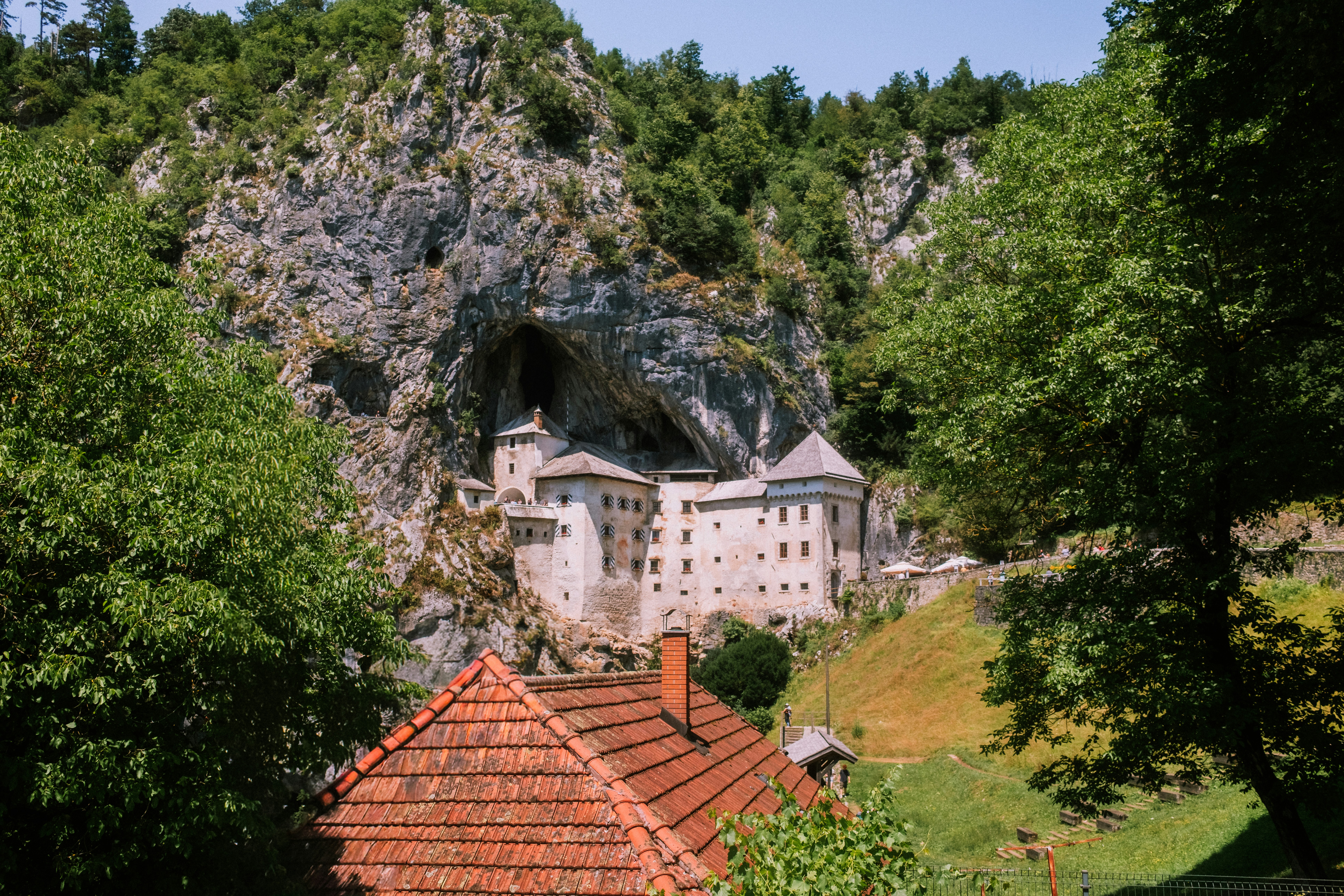 Castle in the Cliff: A Mountain Fortress Nestled Behind Red Roofs