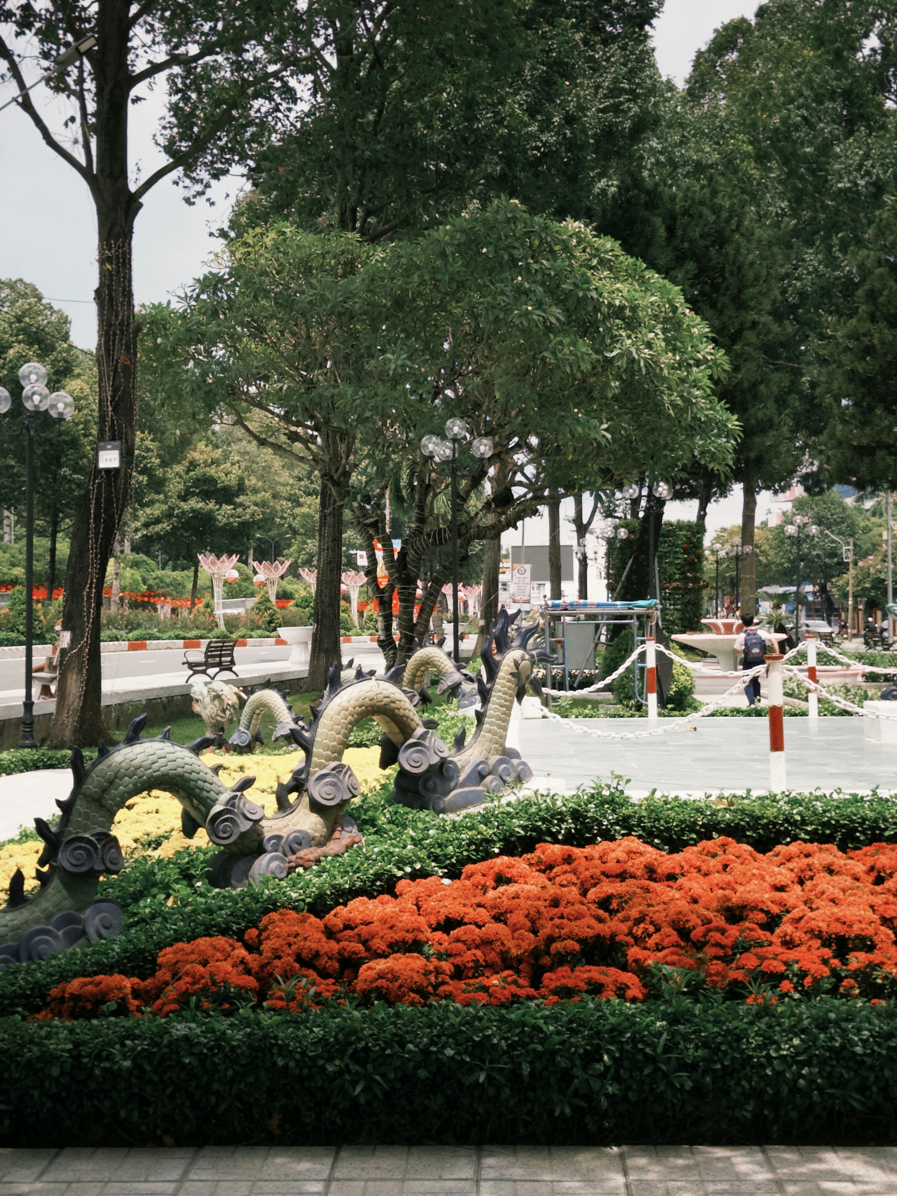 Colorful Garden Dragons: A Sunlit Park Scene with Sculptural Serpents