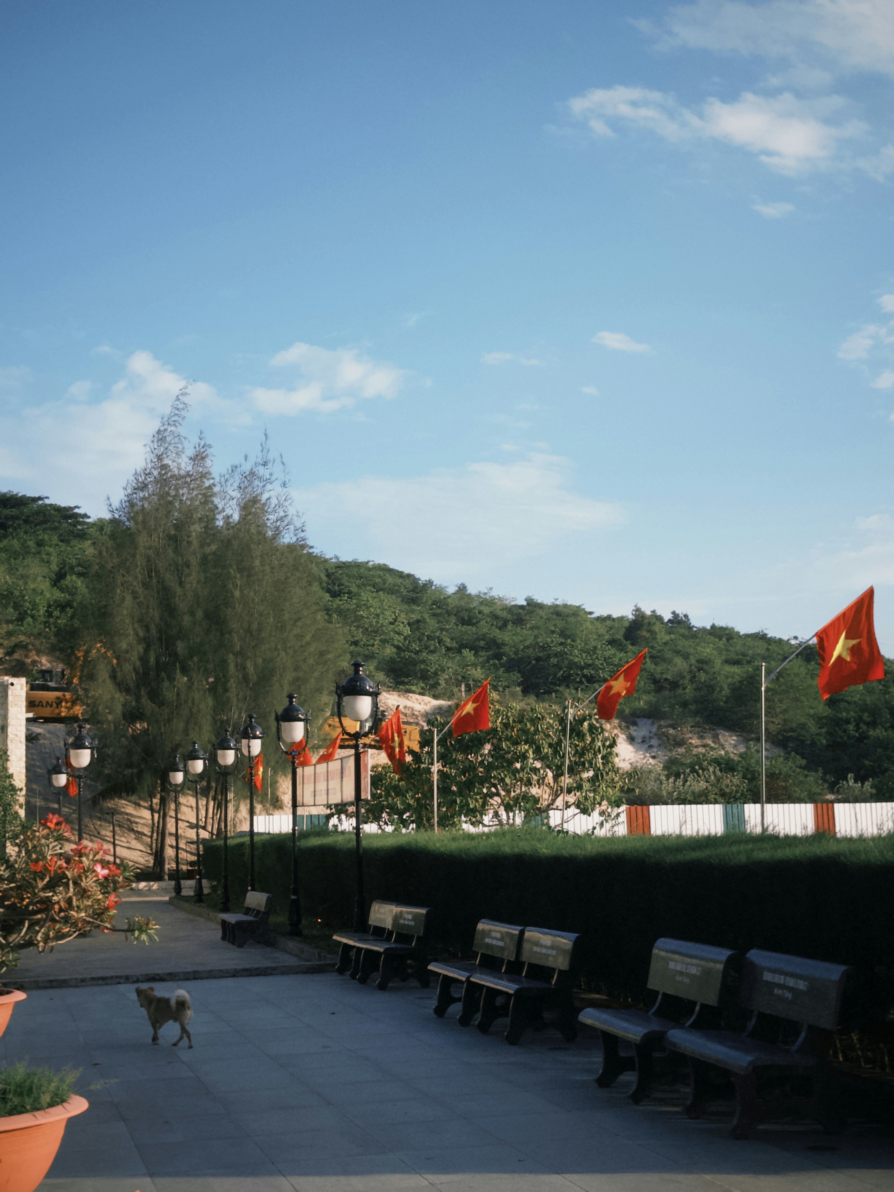 Flags and Lanterns lining a tranquil park under a clear sky