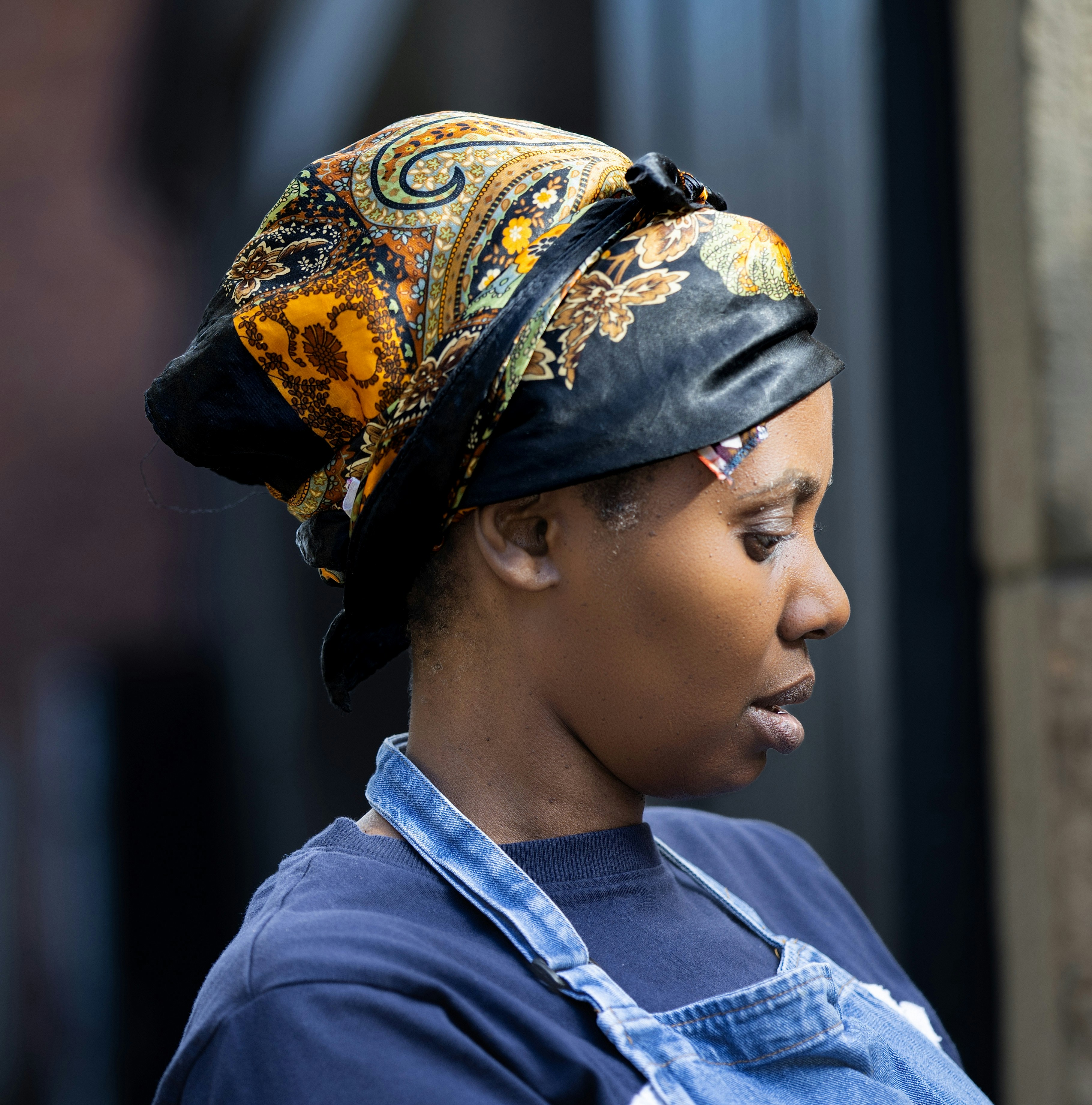Portrait of Quiet Focus: a woman with a patterned headscarf in profile