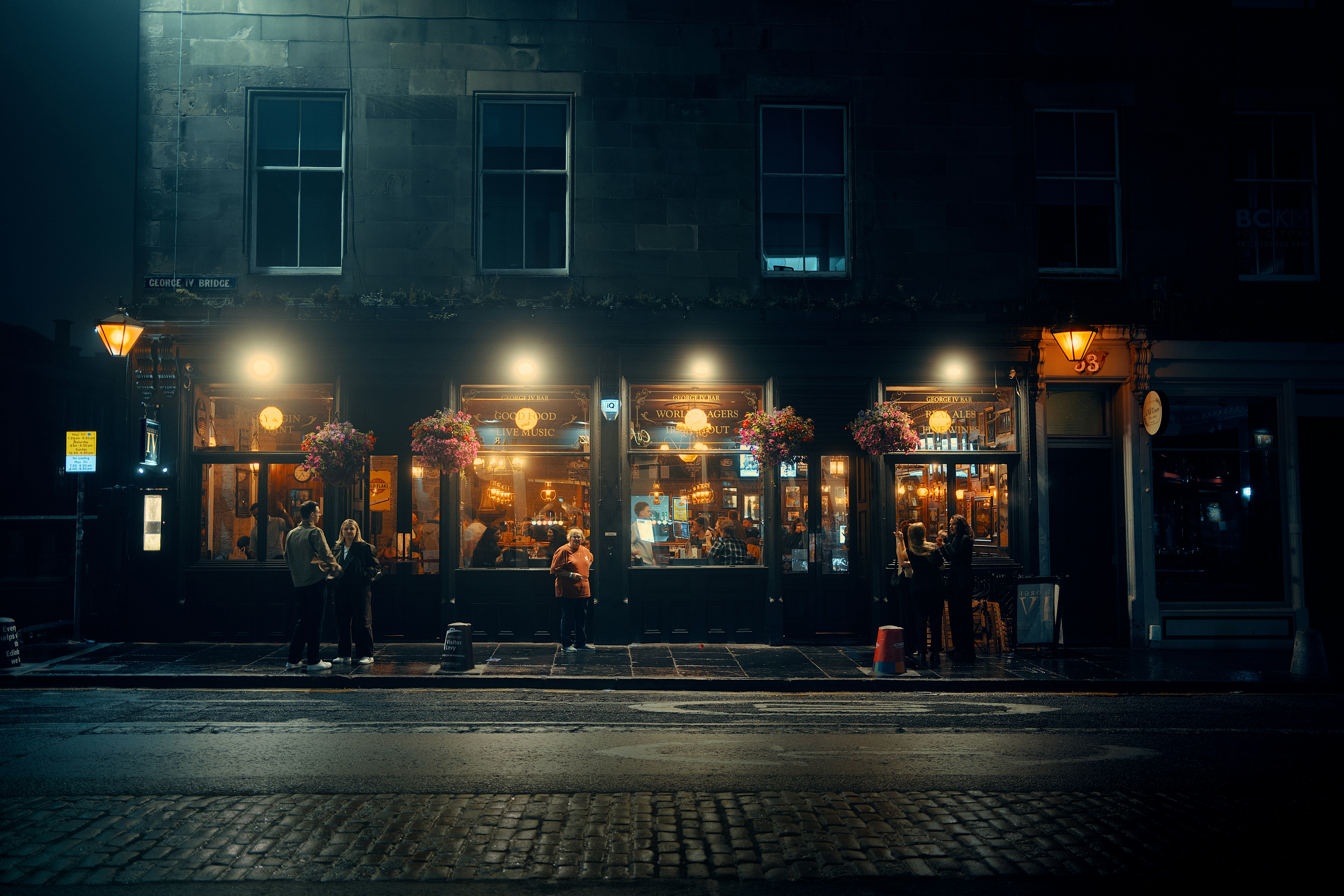 Neon-lit Shopfront Birds-Eye on a Quiet Street