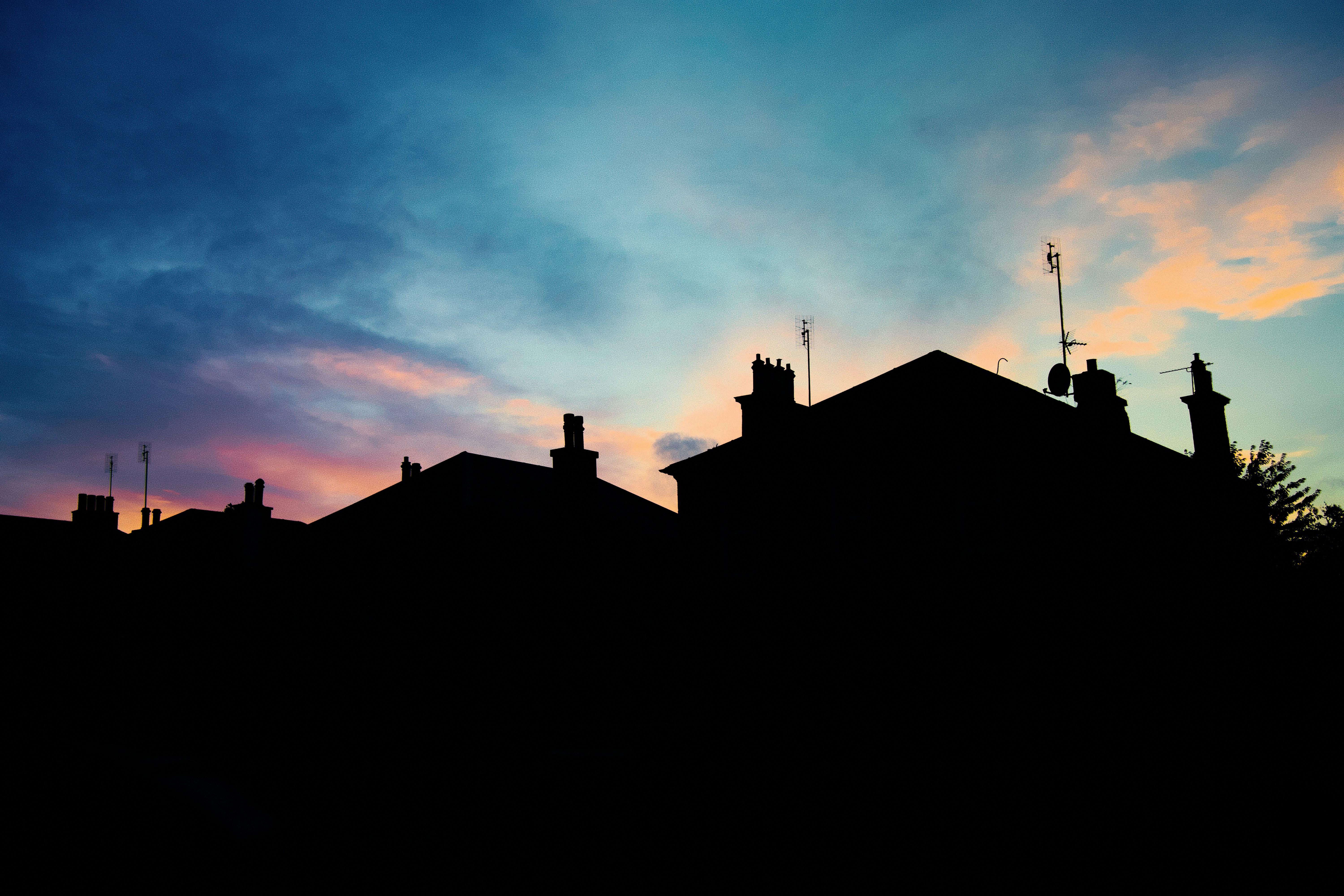 Silhouette Skyline at Dusk: Rooftops Against a Cyan-to-Orange Sky