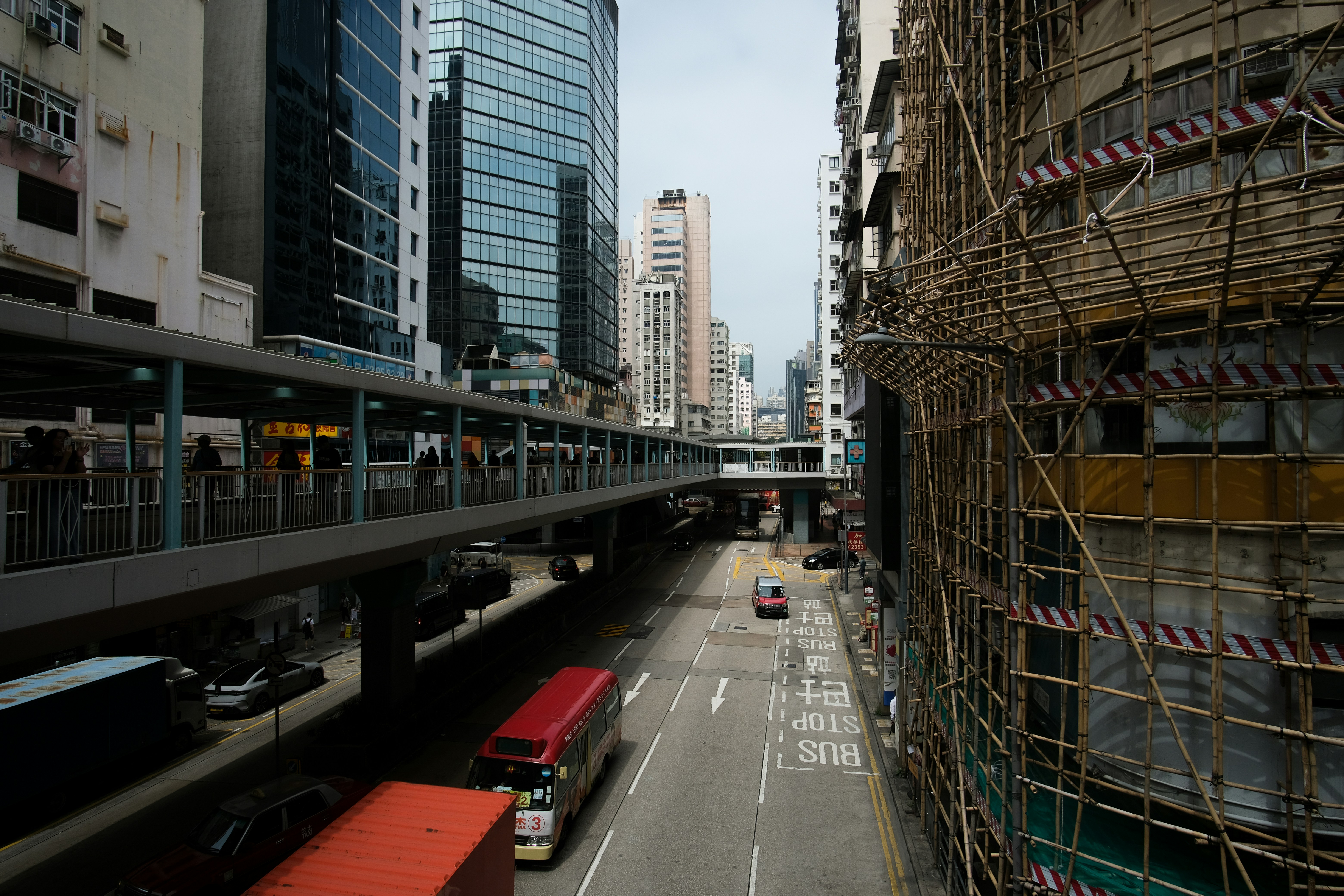 Urban Junction: A City Street Framed by Glass Towers and Brick Scaffold