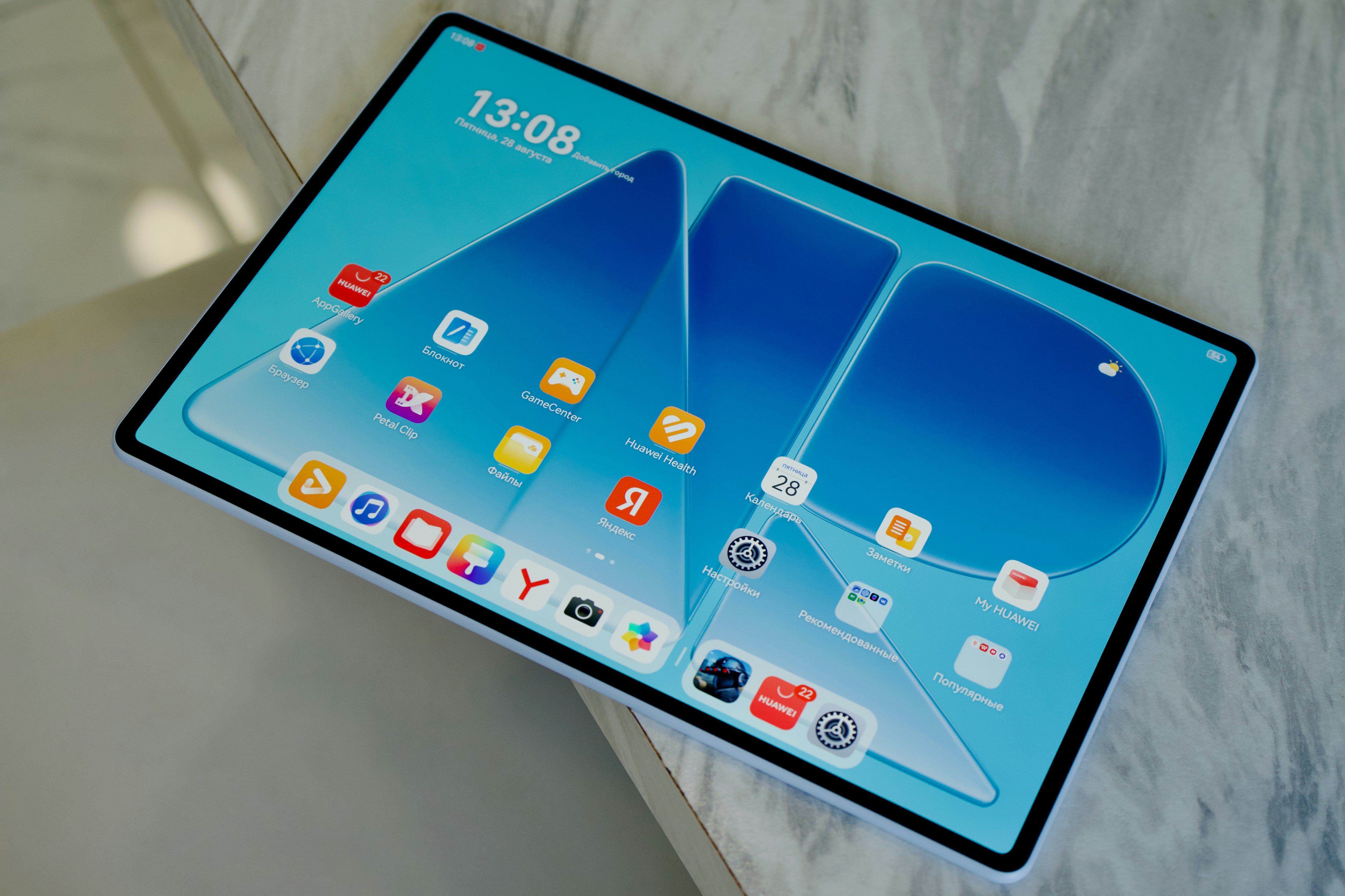 Angled tablet display resting on a marble ledge, glowing icons and a blue-hued wallpaper
