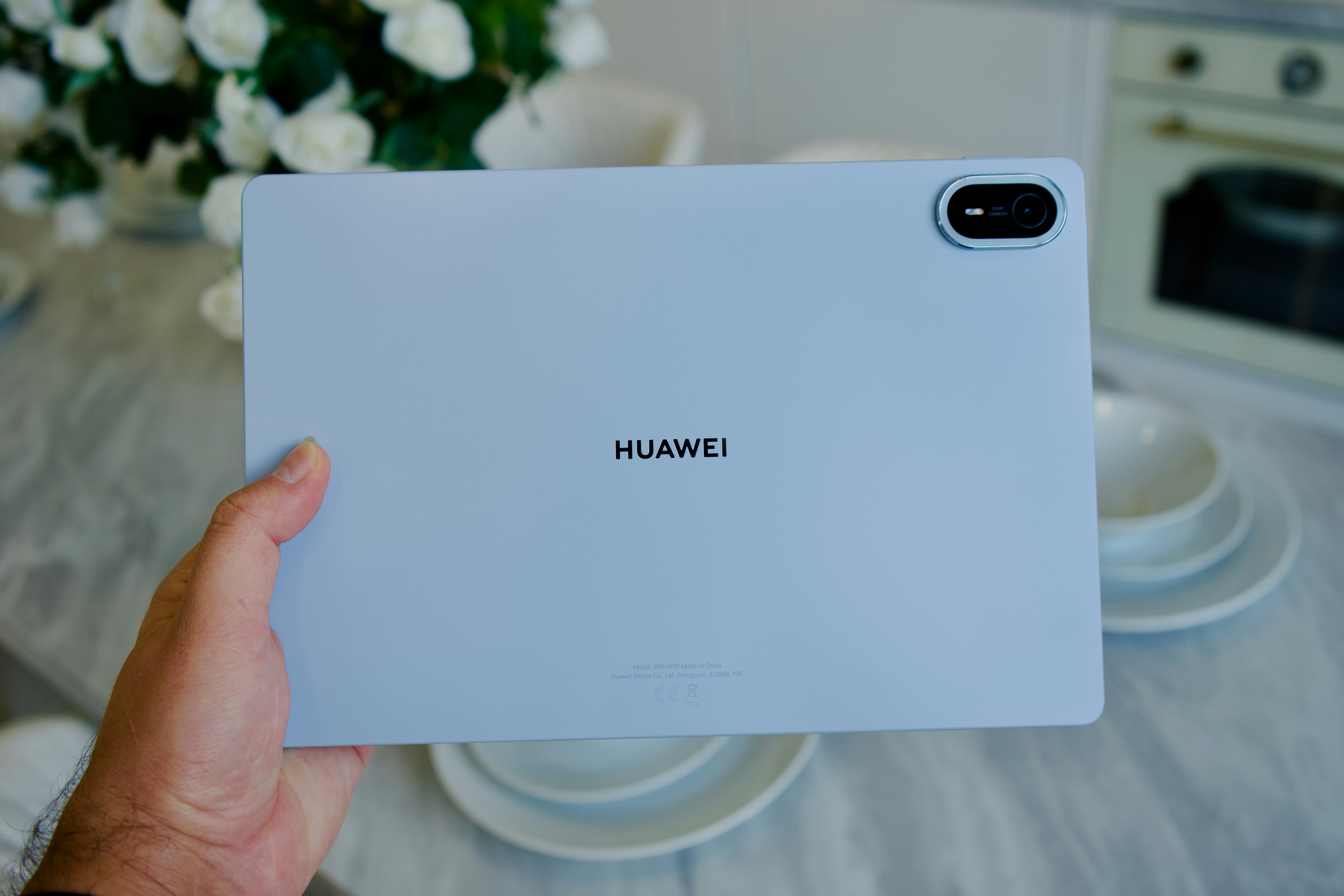 Glossy Huawei Tablet in Hand: Subtle Brand on White Kitchen Counter