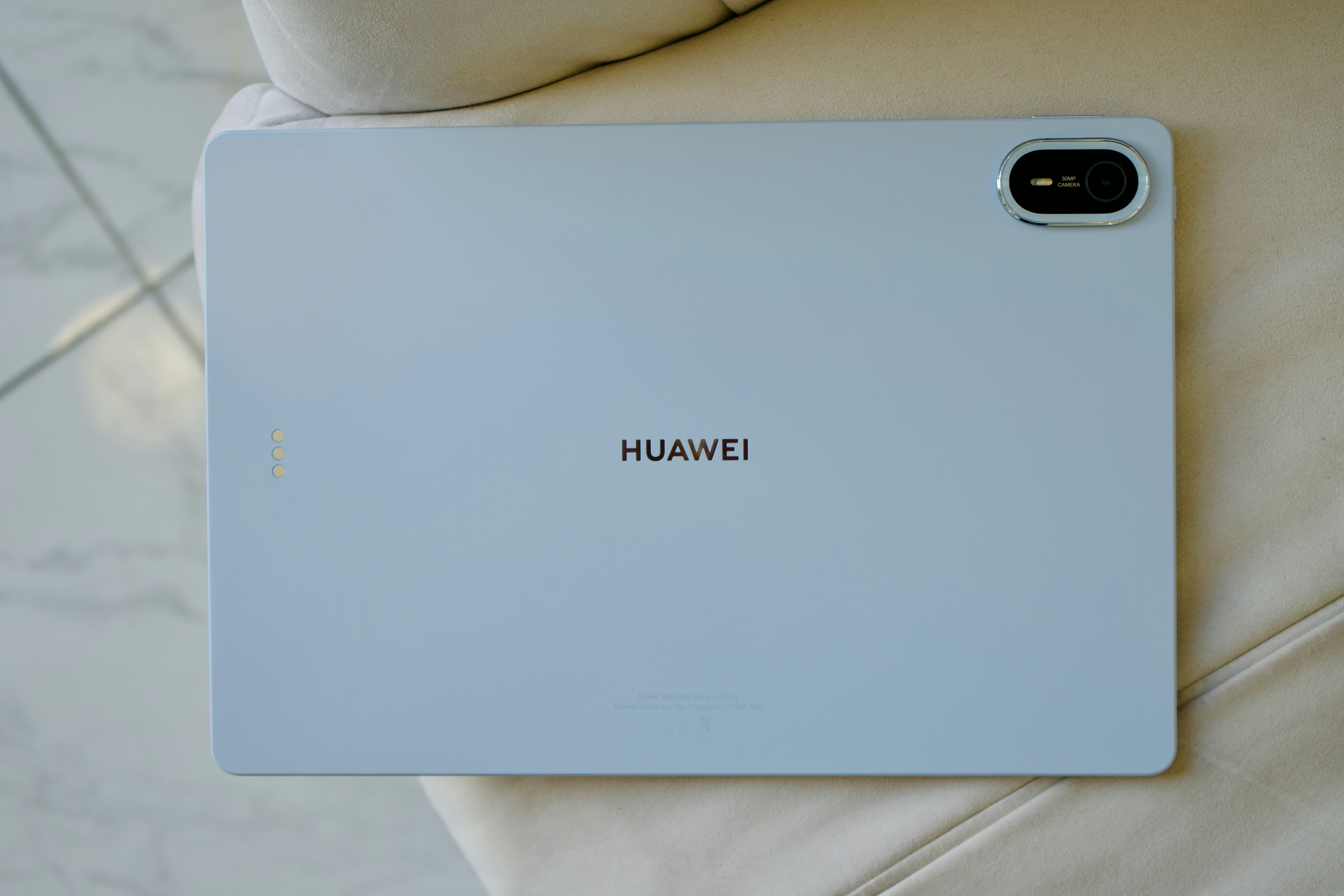 Huawei tablet resting on a cream-colored surface, camera module at the top-right