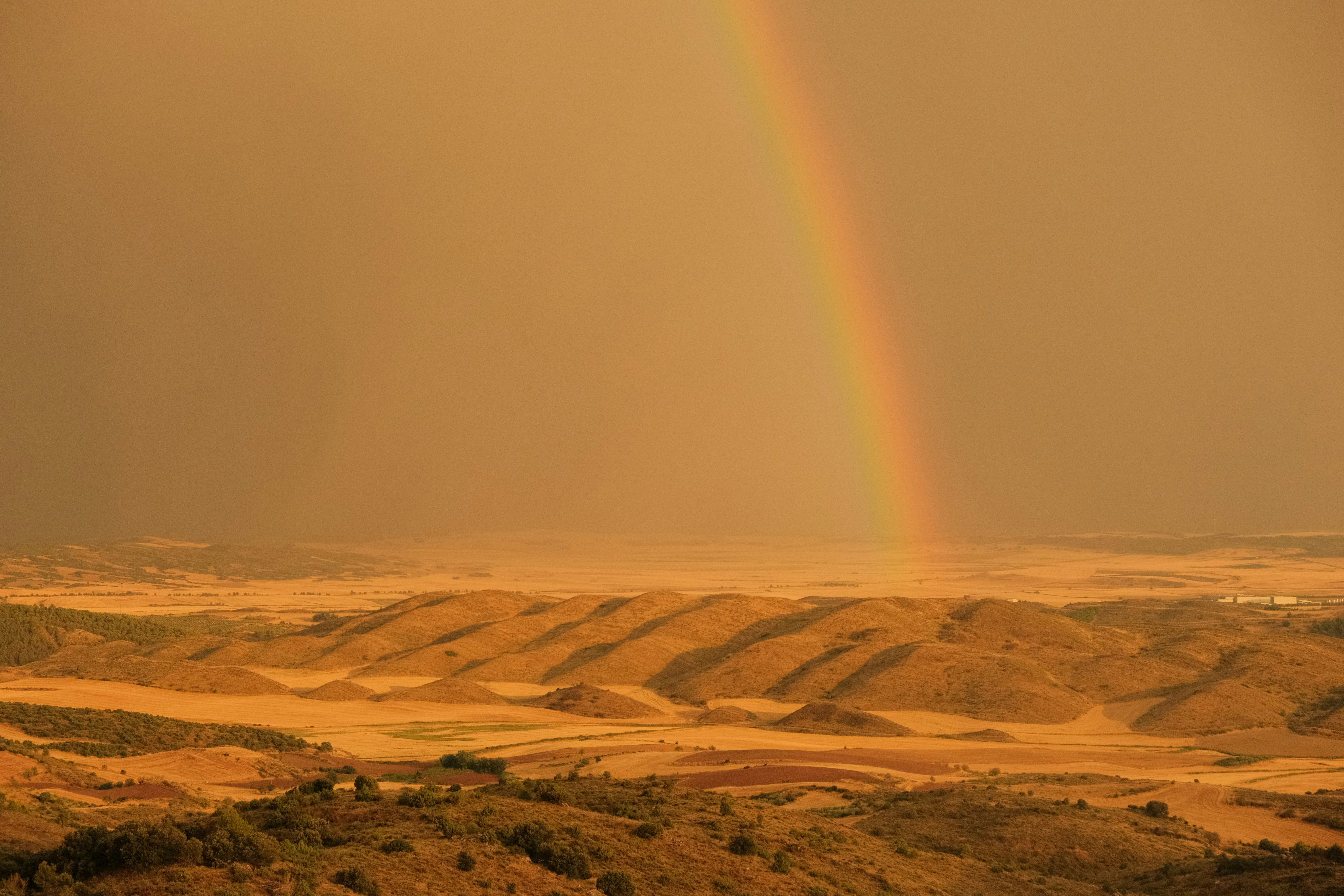 Rainbow over the ochre dunes: a desert lightshow