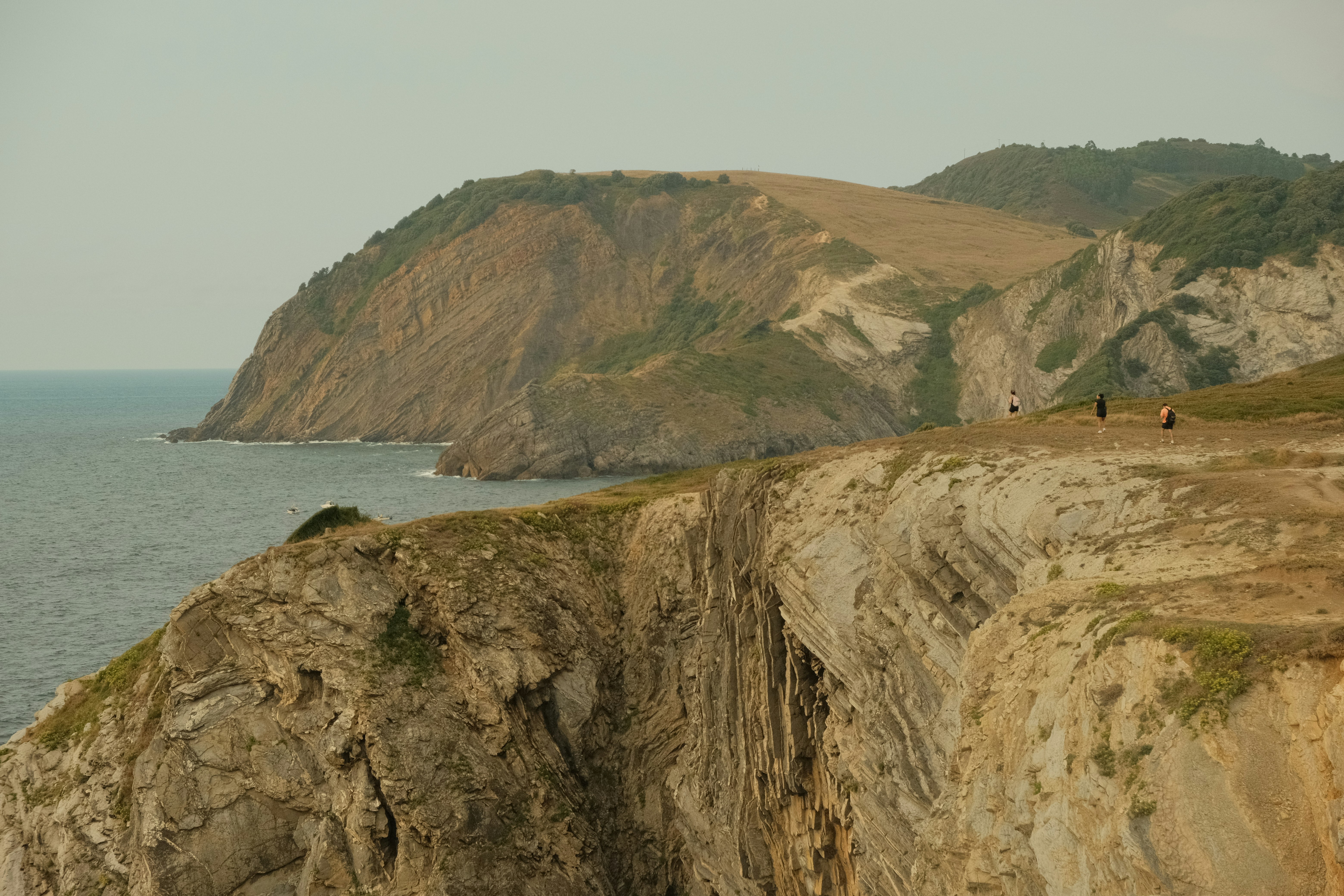 Cliffside Path: Two Figures Trek the Edge of the Canyon