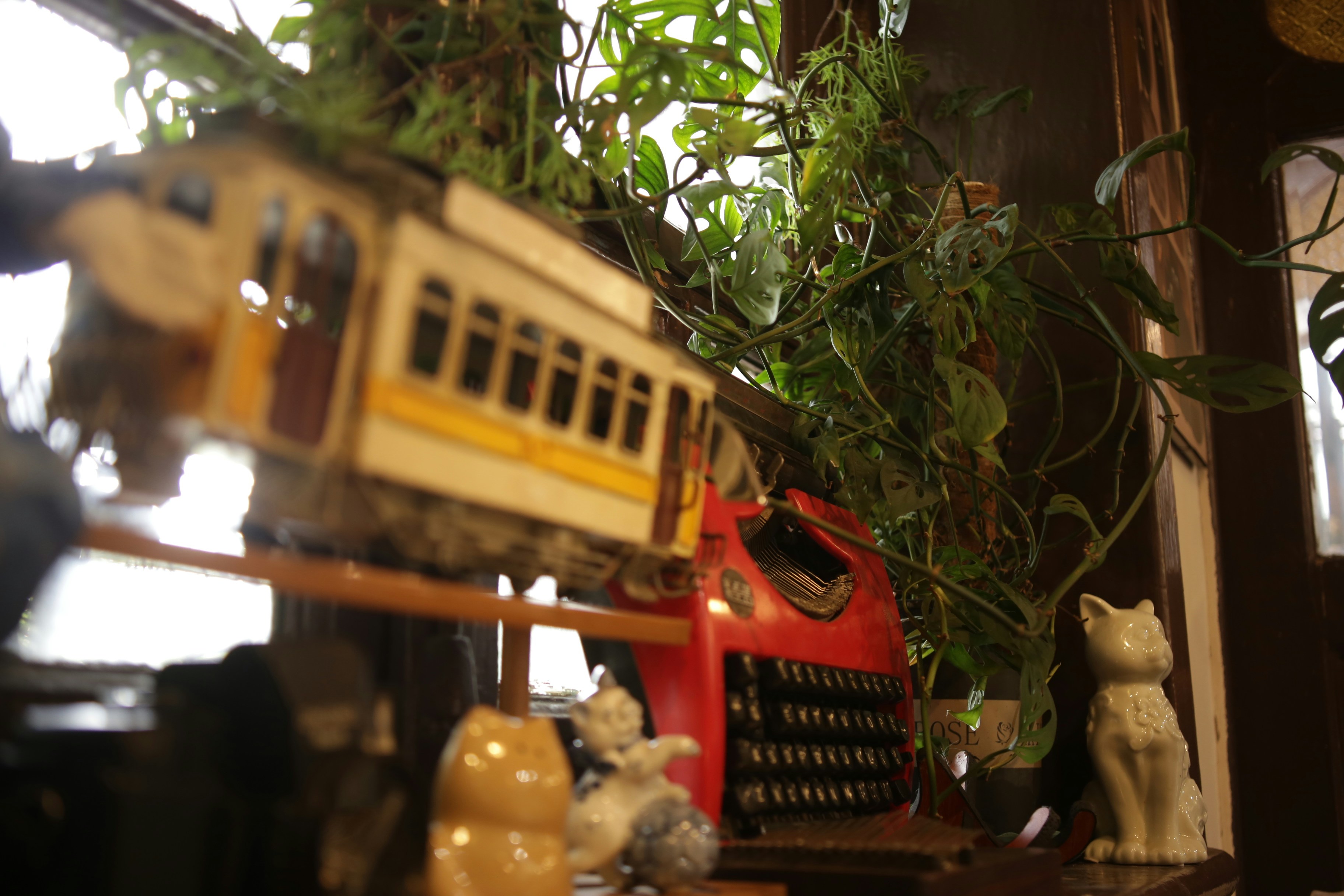 Miniature Train, Red Radio, and Cat Figurines on a Wooden Shelf