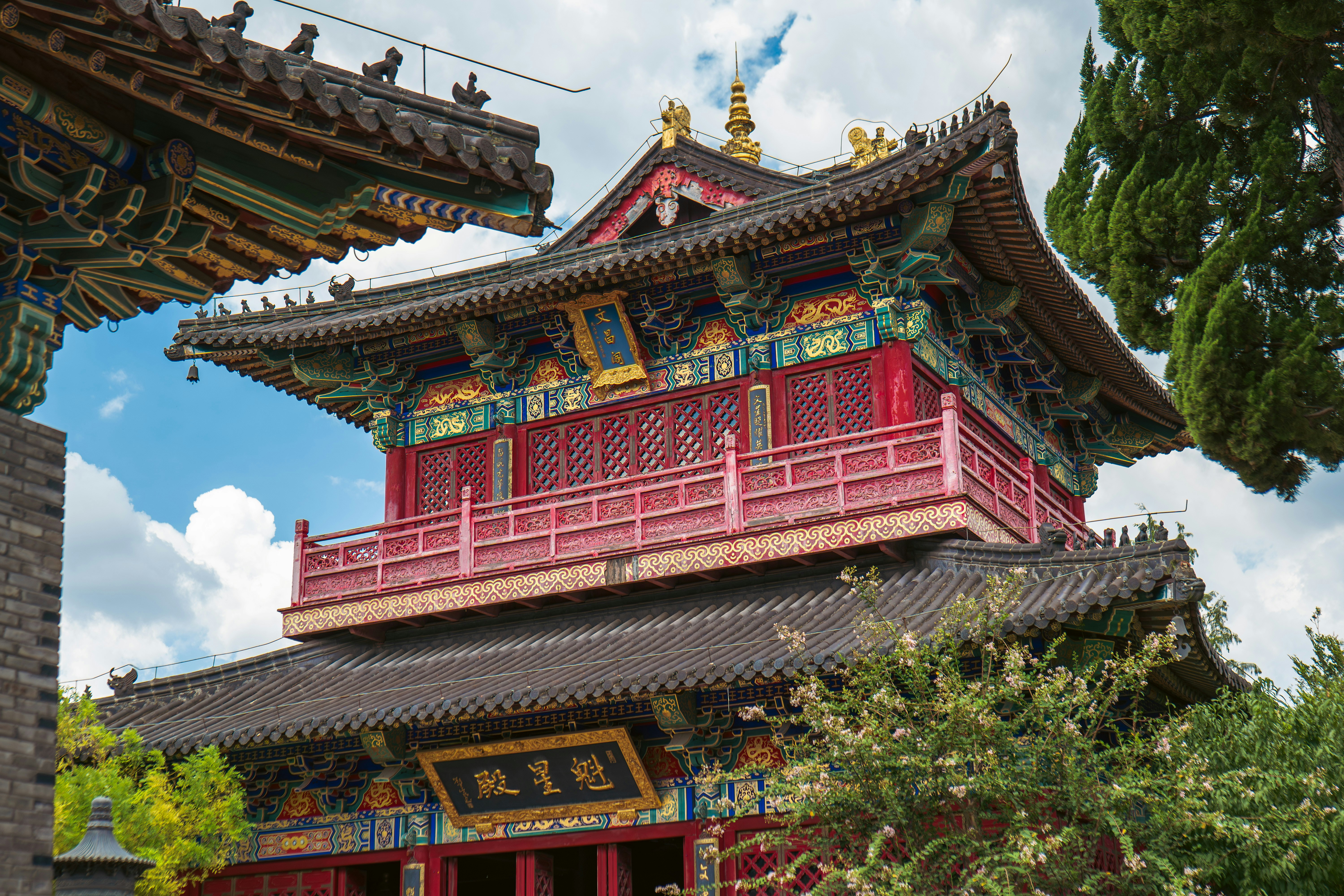 Red-templed pavilion rising above a lantern-lit eave