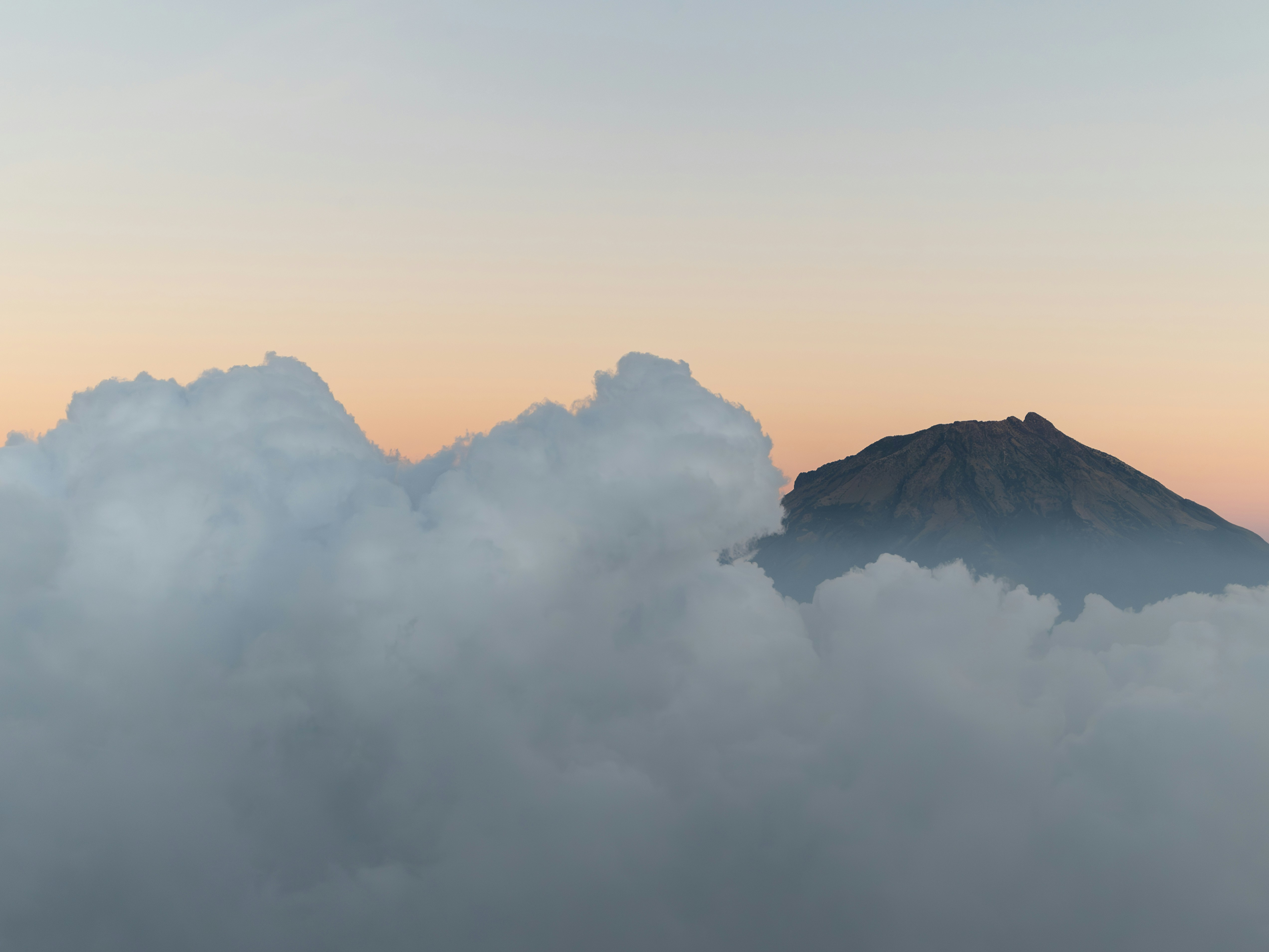 Above the Ember Horizon: Cloud Veil over a Distant Peak