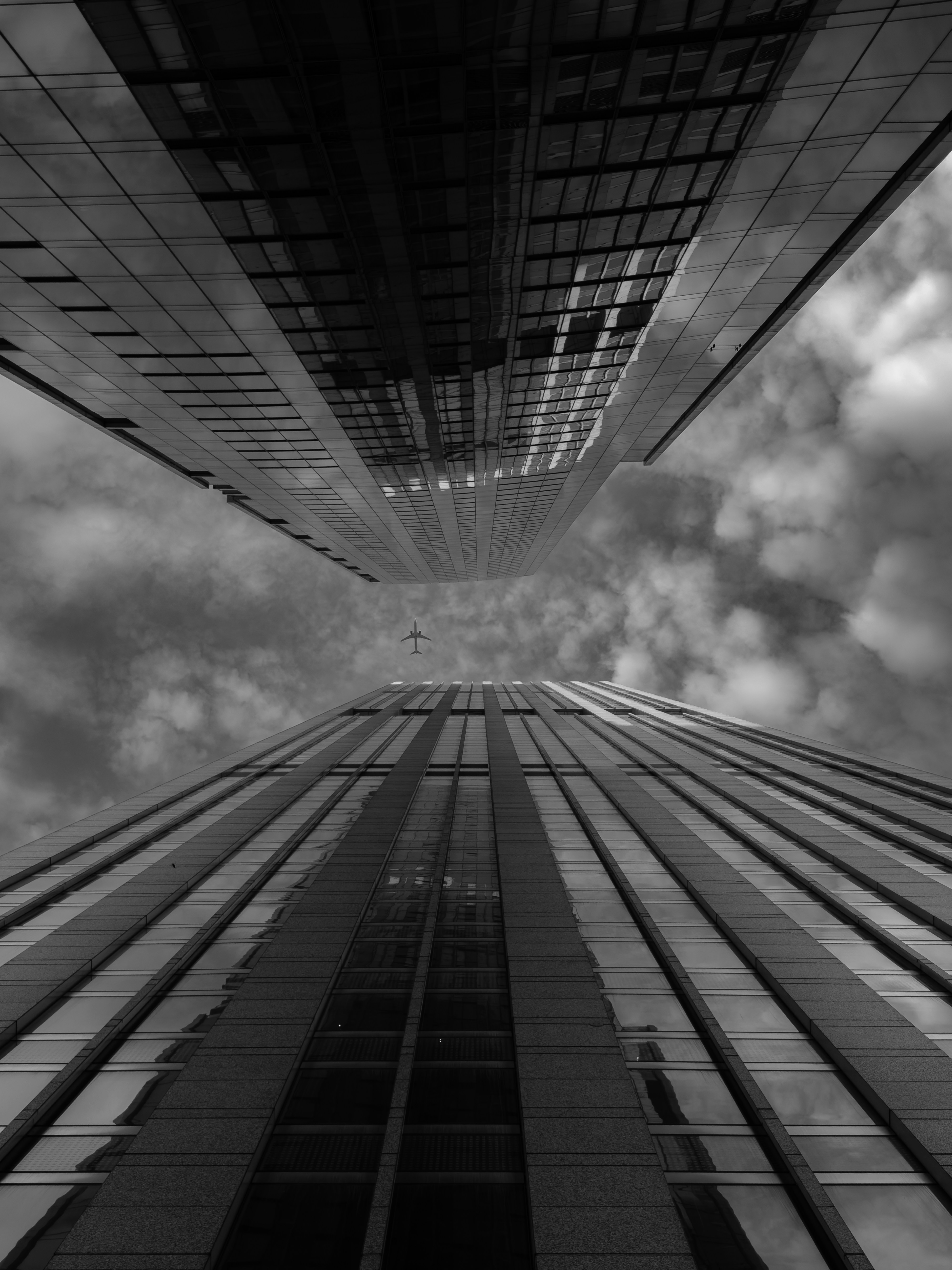 Skyward Ascent: A Black-and-White Vantage Between Twin Towers