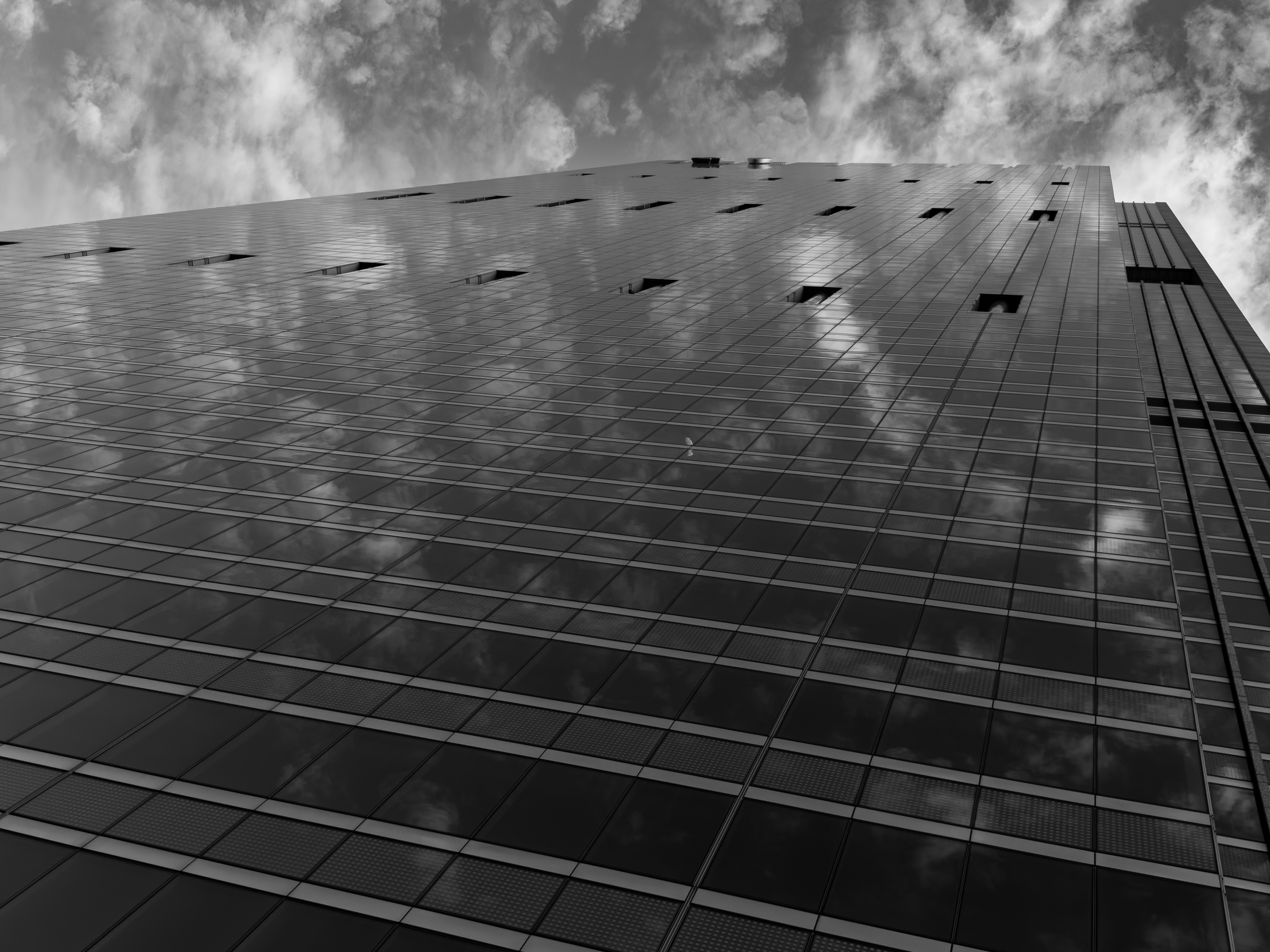 Monolithic Glass Facade Reaching Toward a Dramatic Sky